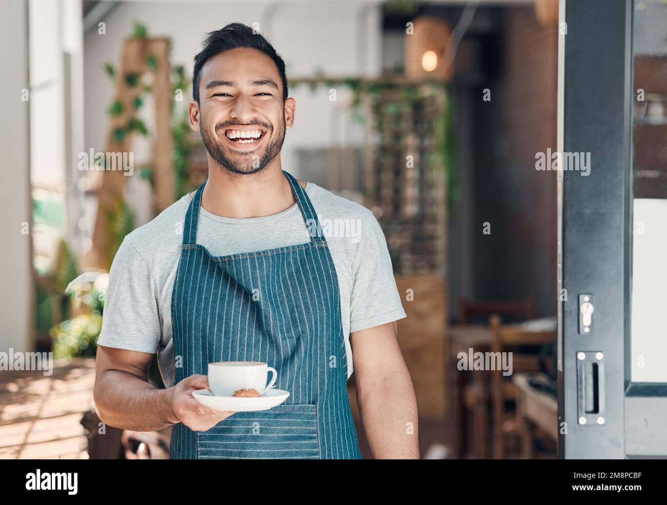 Portrait of one young hispanic waiter serving a cup of coffee while ...
