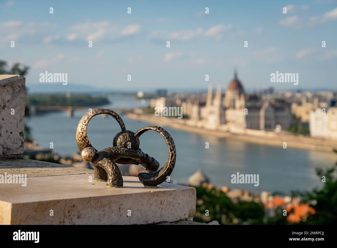 A selective of a copper rabbit statue on a stone facing the river Stock ...