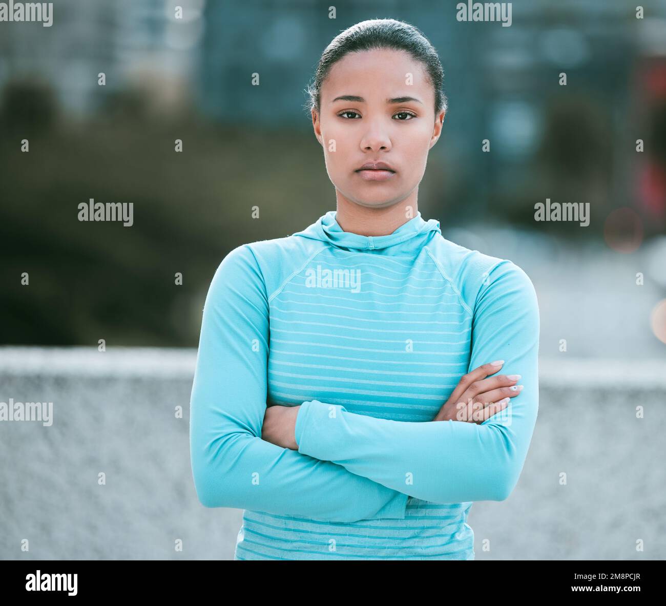 Portrait of one serious young mixed race woman standing with arms ...