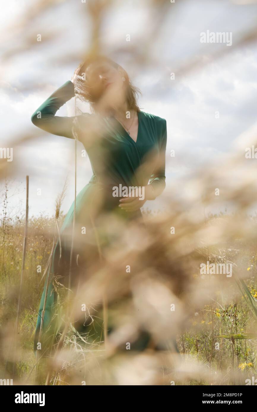 Serie of photos of female model in green dress posing on meadow ...