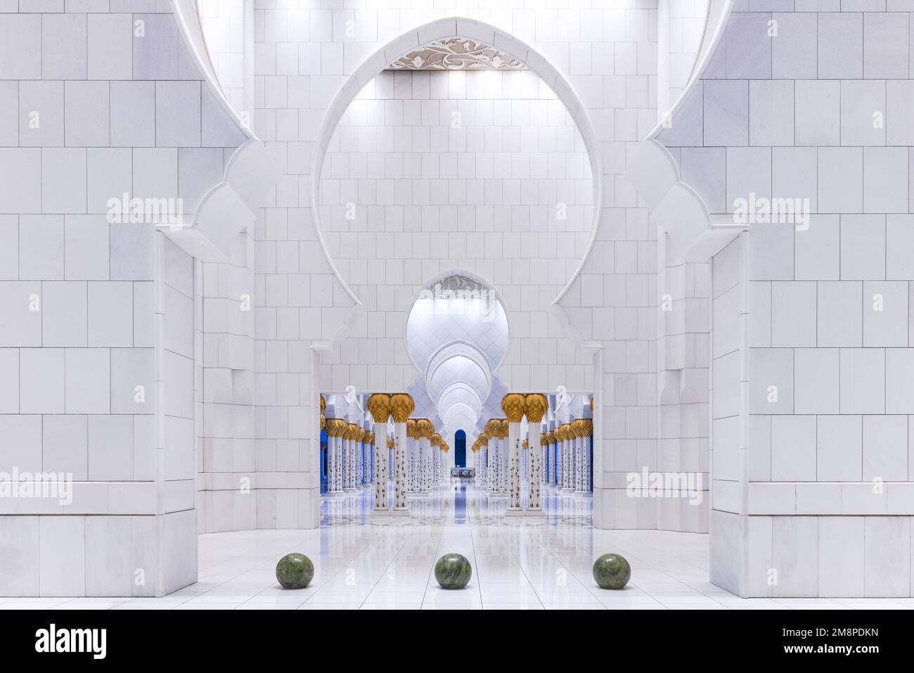 Symmetrical view of a white marble colonnade at Sheik Zayed mosque in ...