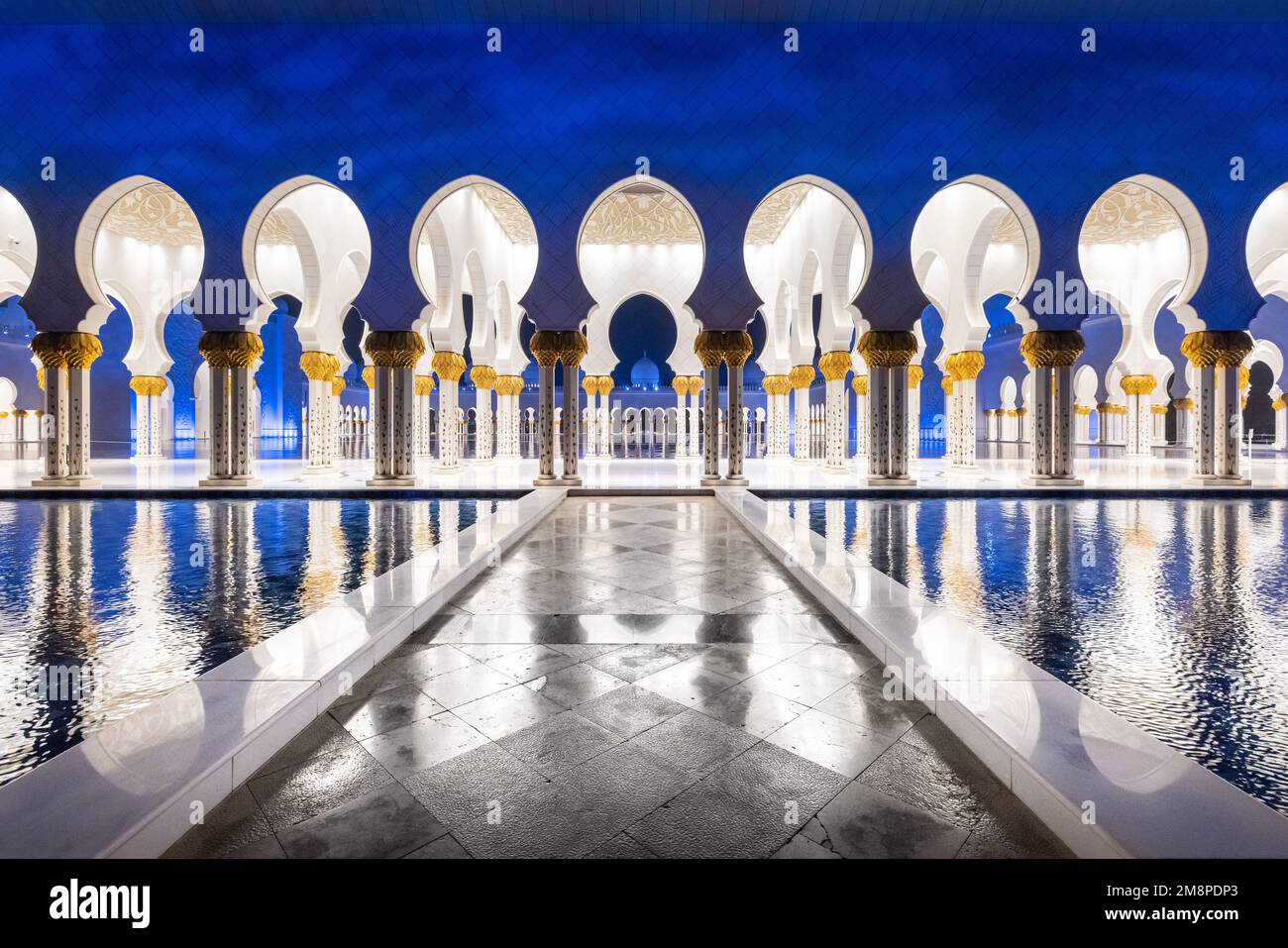 Symmetrical nightshot of the colonnade of the Sheik Zhayed mosque, with ...