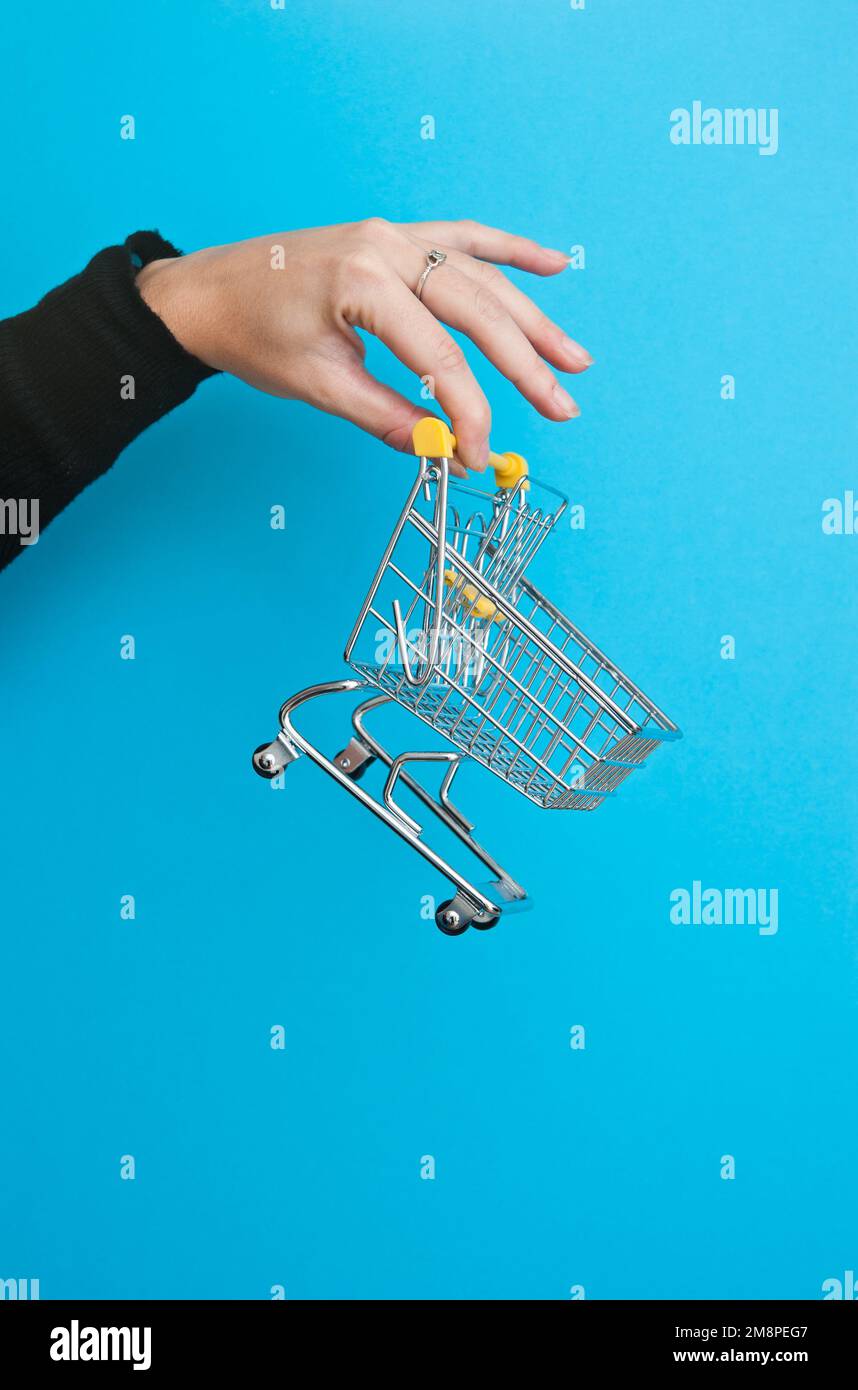 hand holding a shopping cart Stock Photo - Alamy