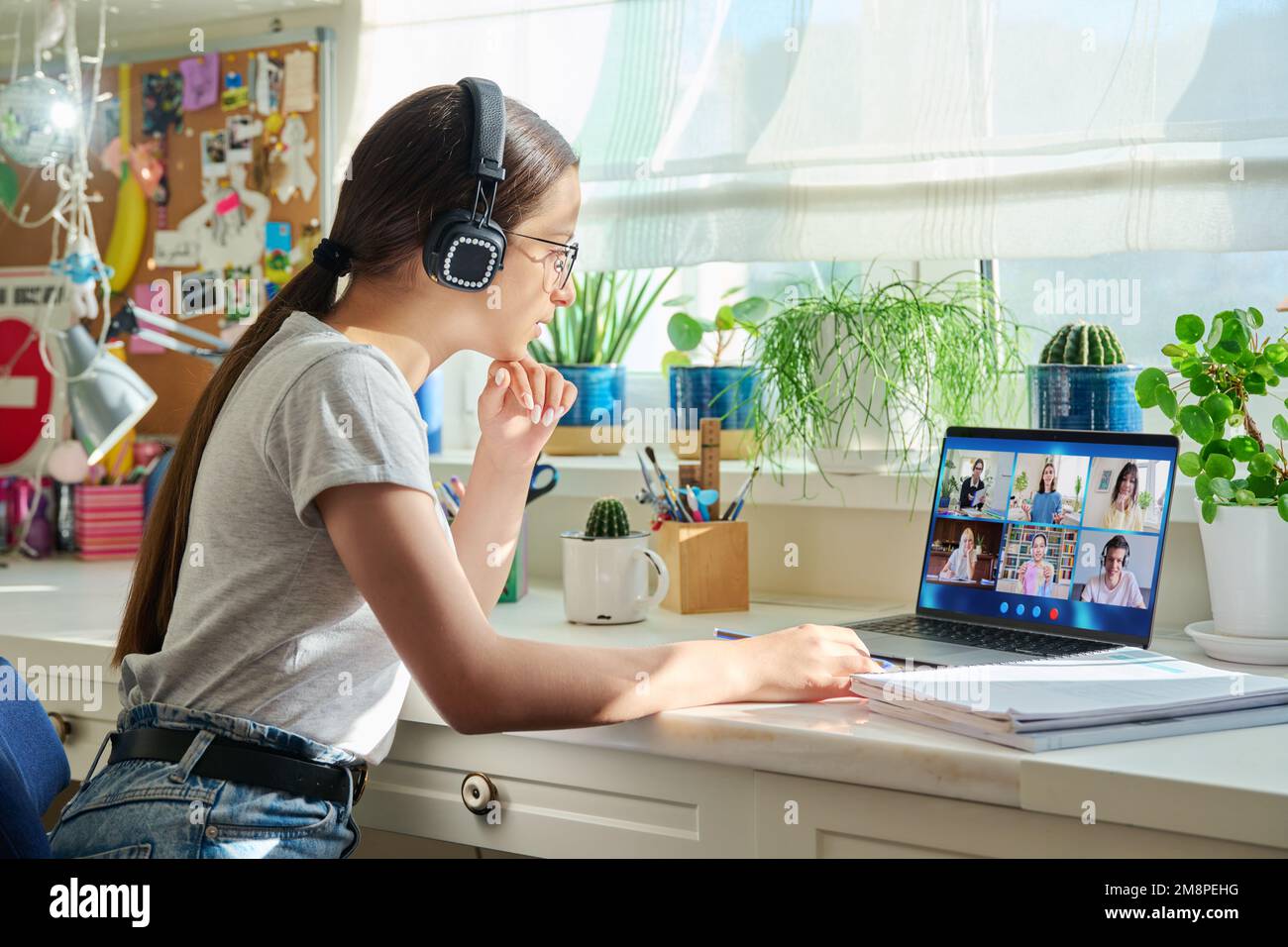 Video conference, teen girl looking at computer screen with group of ...