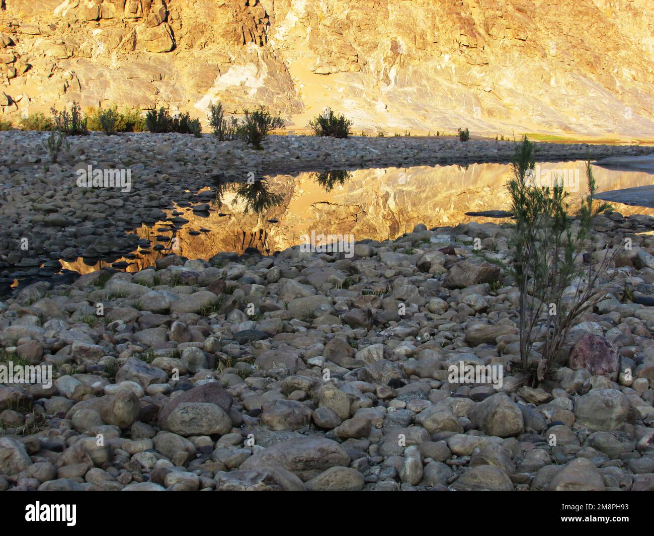 Golden Reflection of the sandstone cliffs within a calm pool in the ...