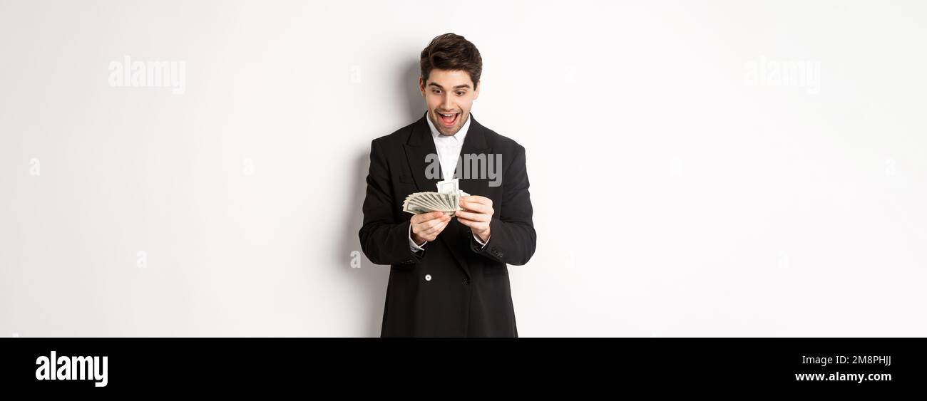 Image of excited handsome businessman, counting money and smiling ...