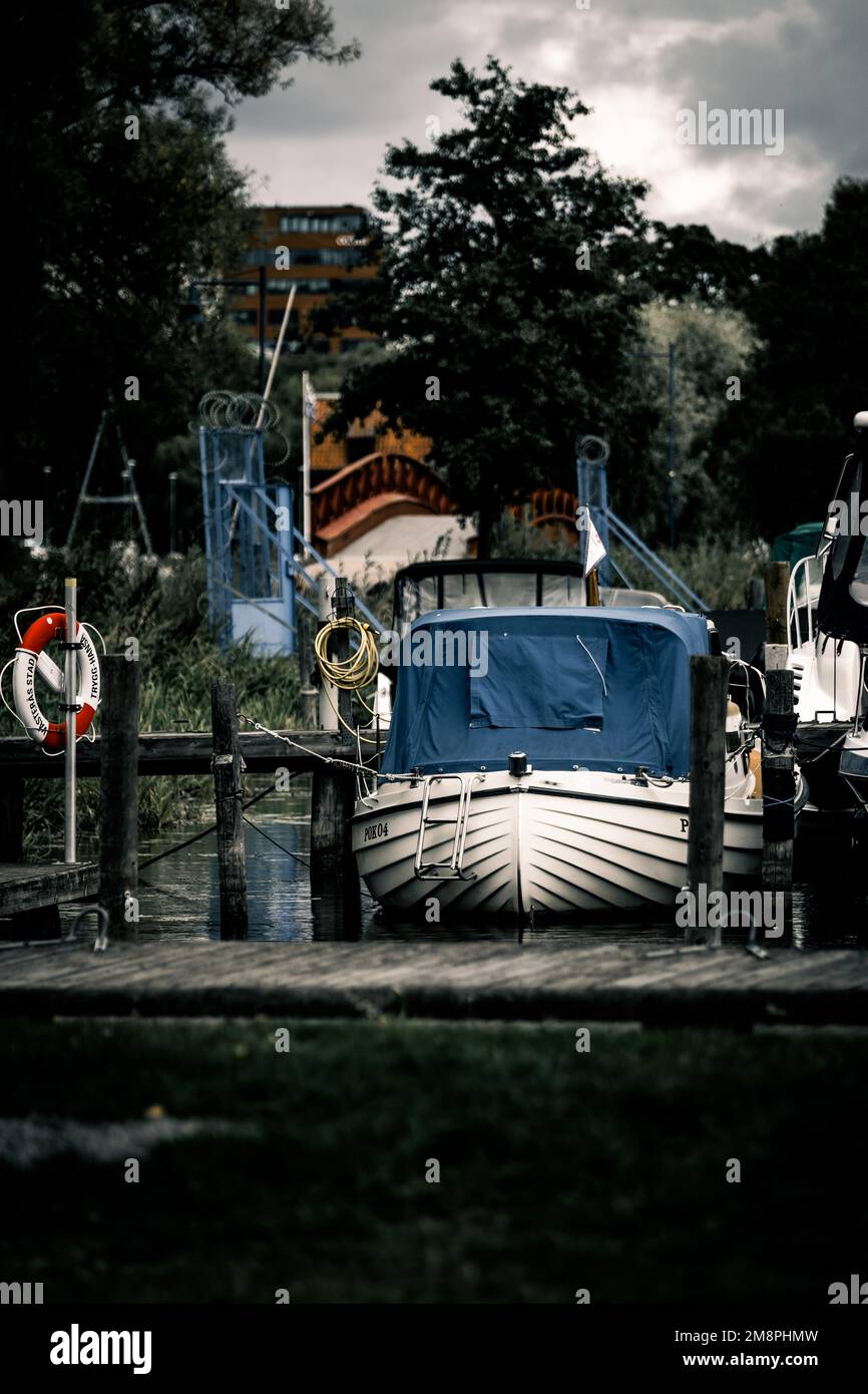 A boat moored at the dock on a cloudy day Stock Photo - Alamy