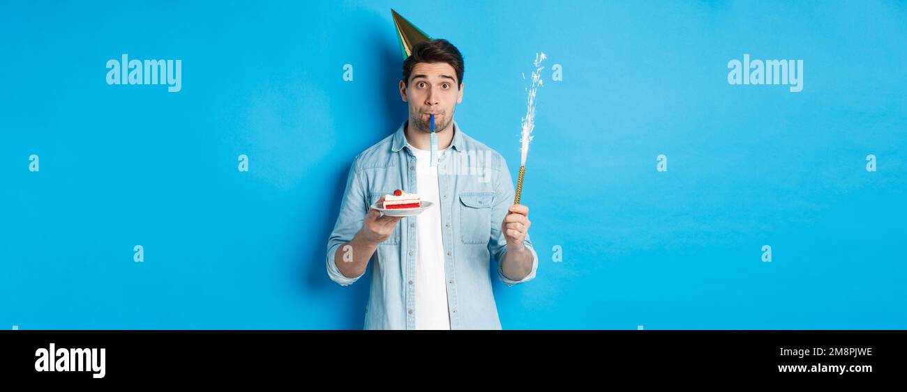 Funny guy celebrating birthday, holding b-day cake, firework and ...