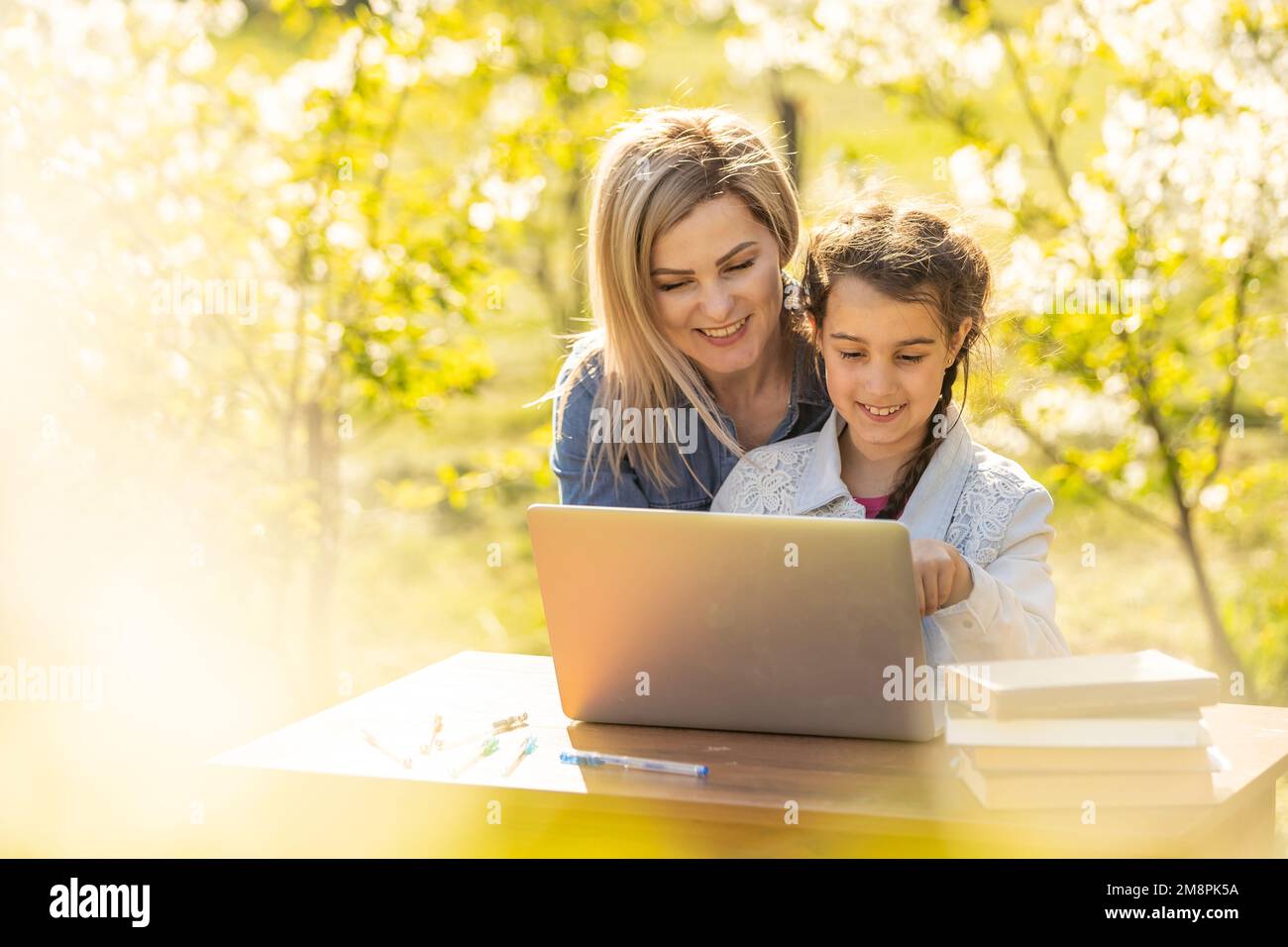 little girl with mom learning on laptop outdoor Stock Photo - Alamy