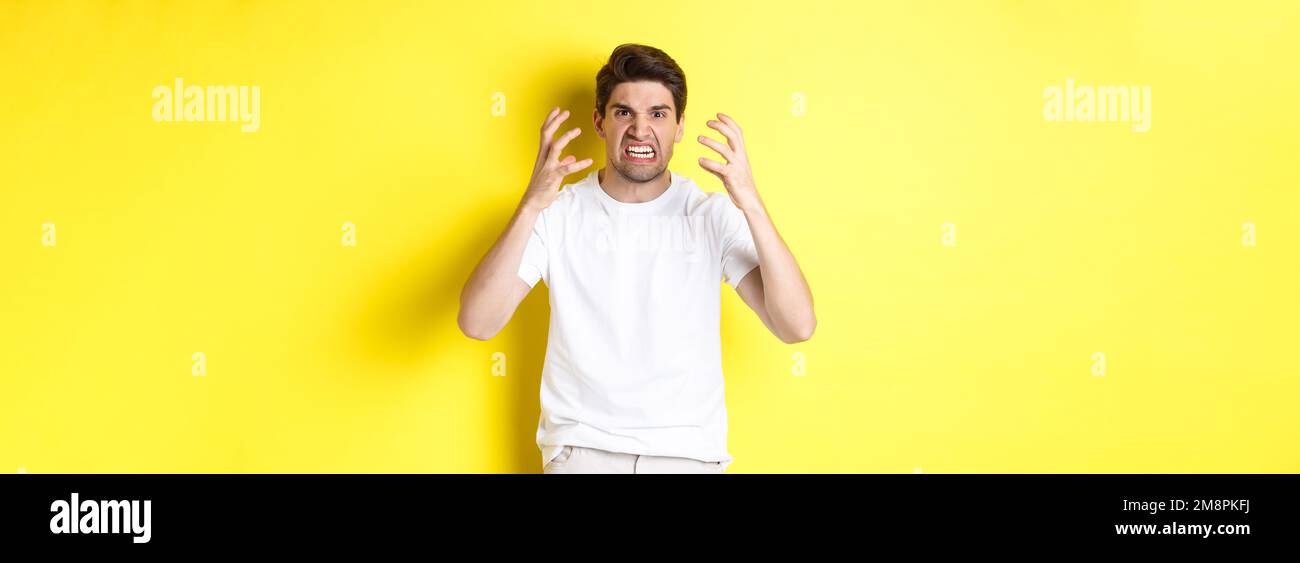Angry man looking mad, grimacing and shaking hands furious, standing ...