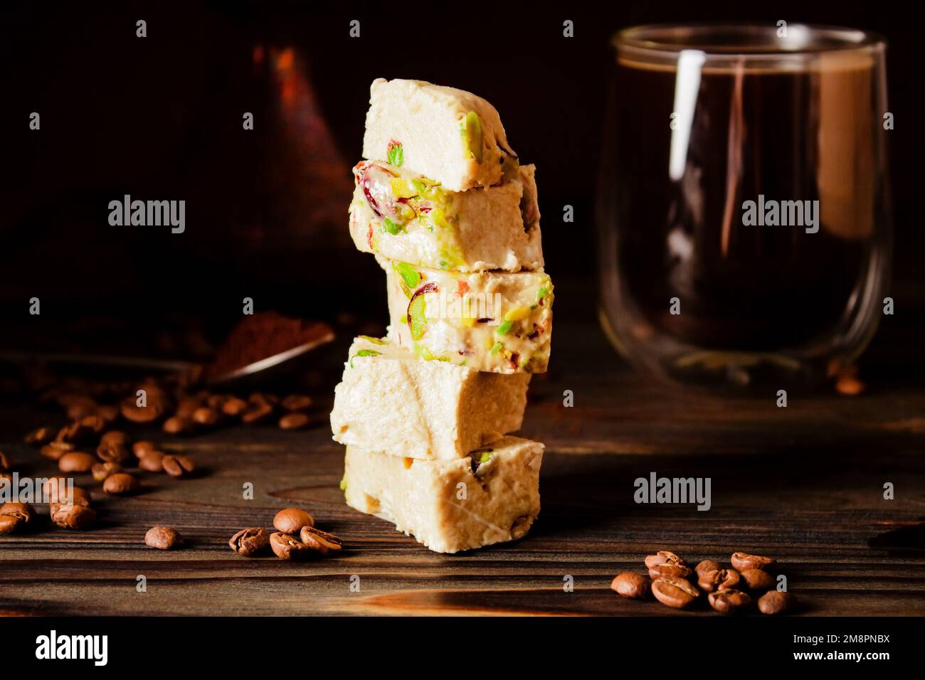 Organic halva with pistachios on a wooden surface. Traditional oriental ...
