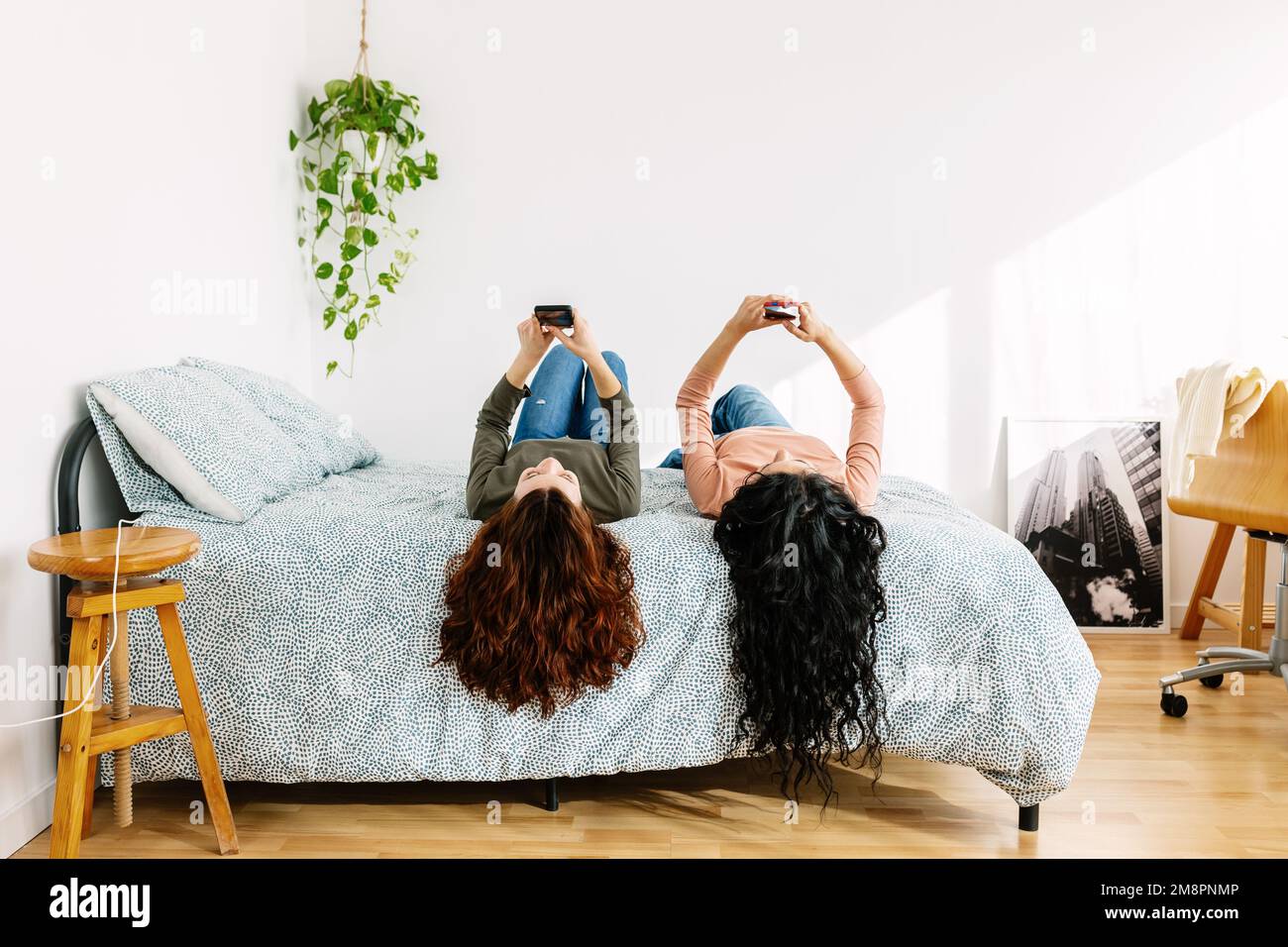 Two teenage student girls using mobile phone in room Stock Photo - Alamy