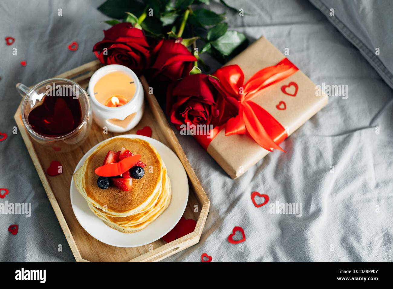 Valentine's day breakfast concept. Pancakes with berries, roses flowers ...