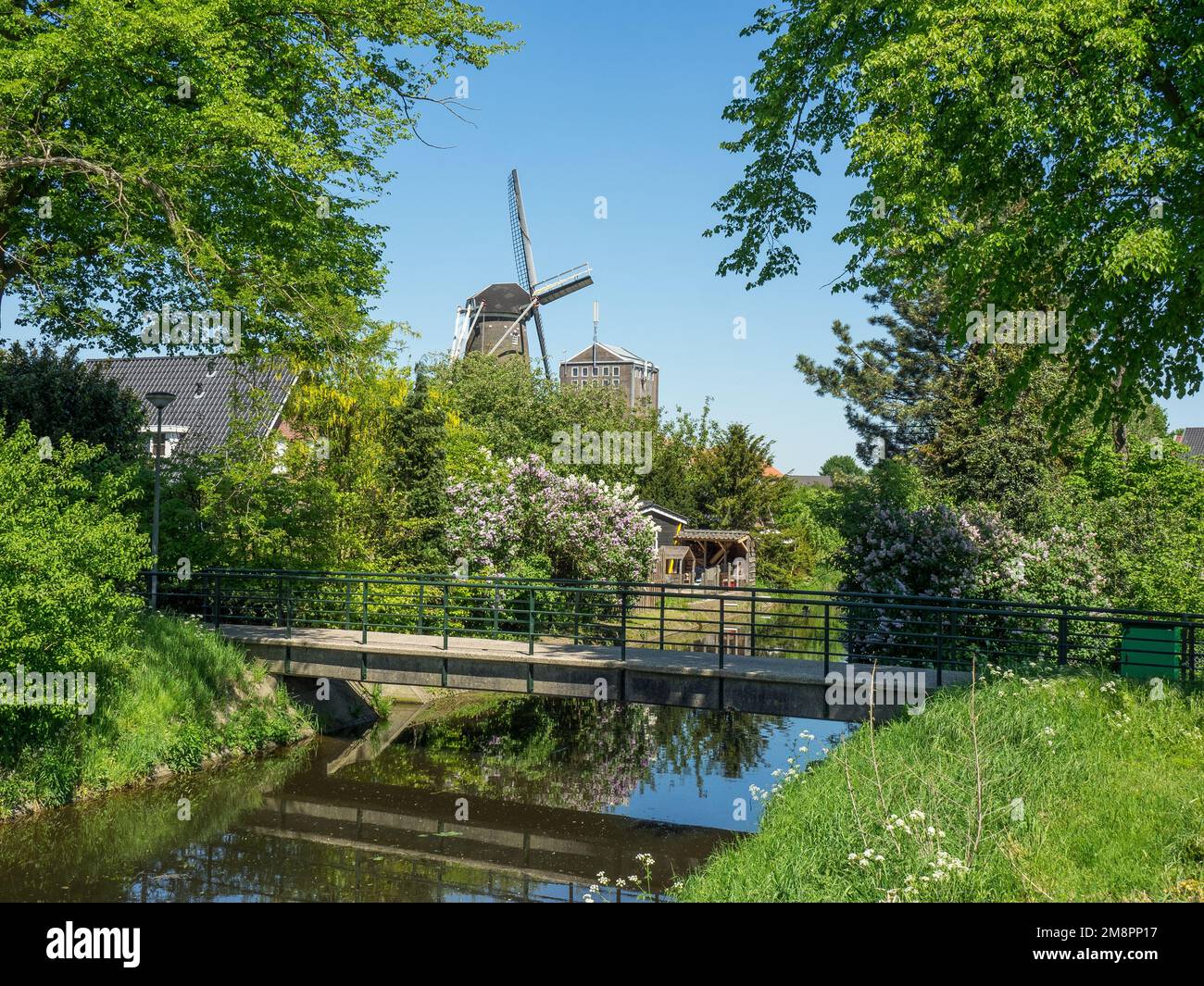 An old windmill on a bank of a river in Bredevoort, Netherlands on a ...