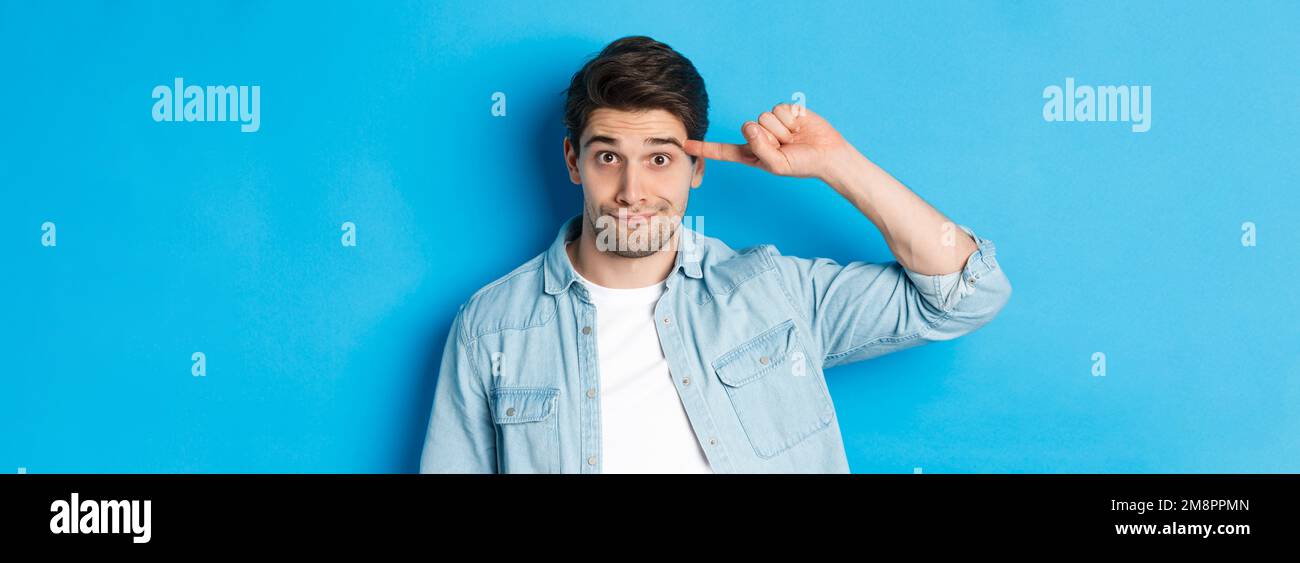 Close-up of man scolding for acting stupid or crazy, rolling finger on ...