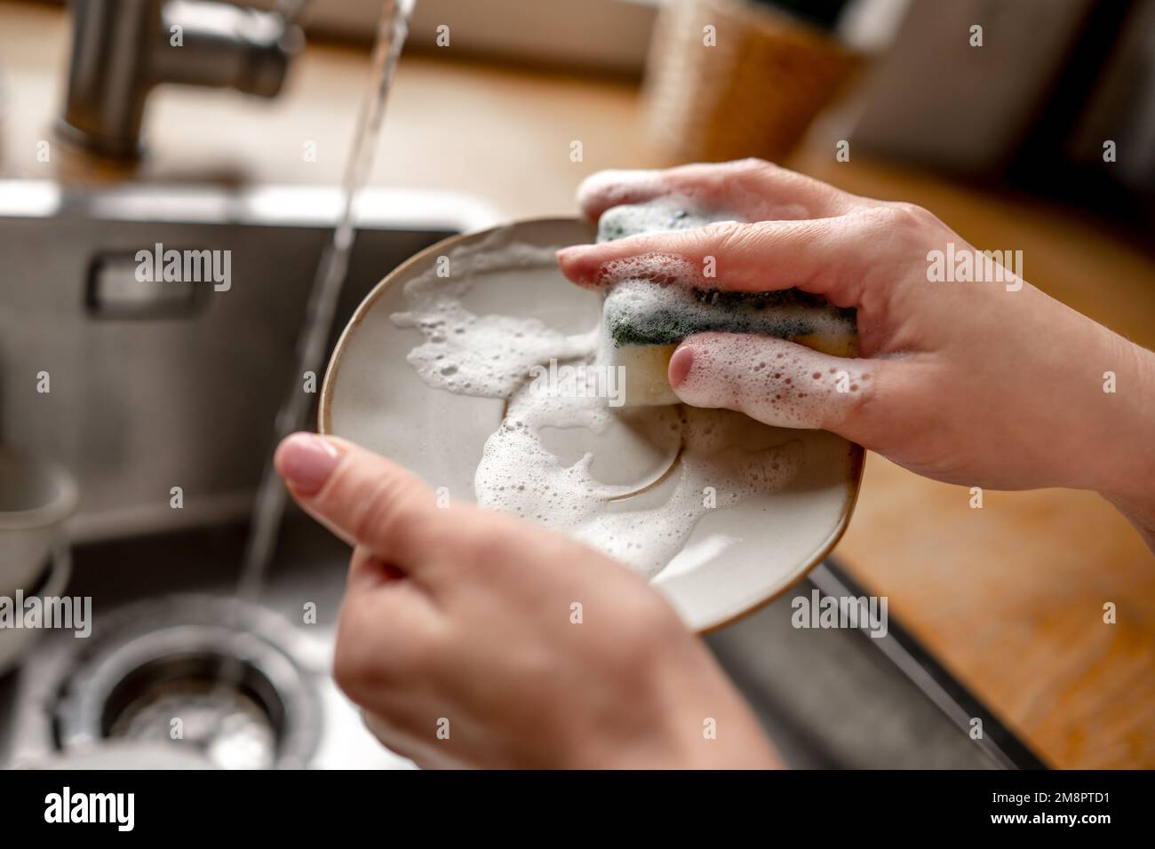 Woman washing plate home hi-res stock photography and images - Alamy