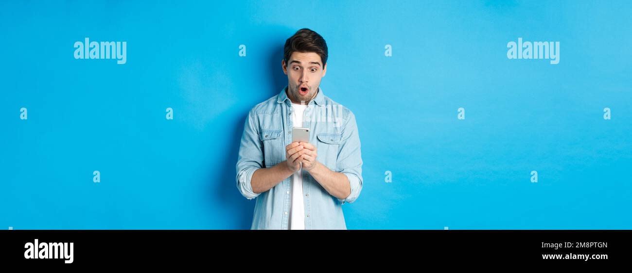 Man looking amazed while checking promo on smartphone, looking ...