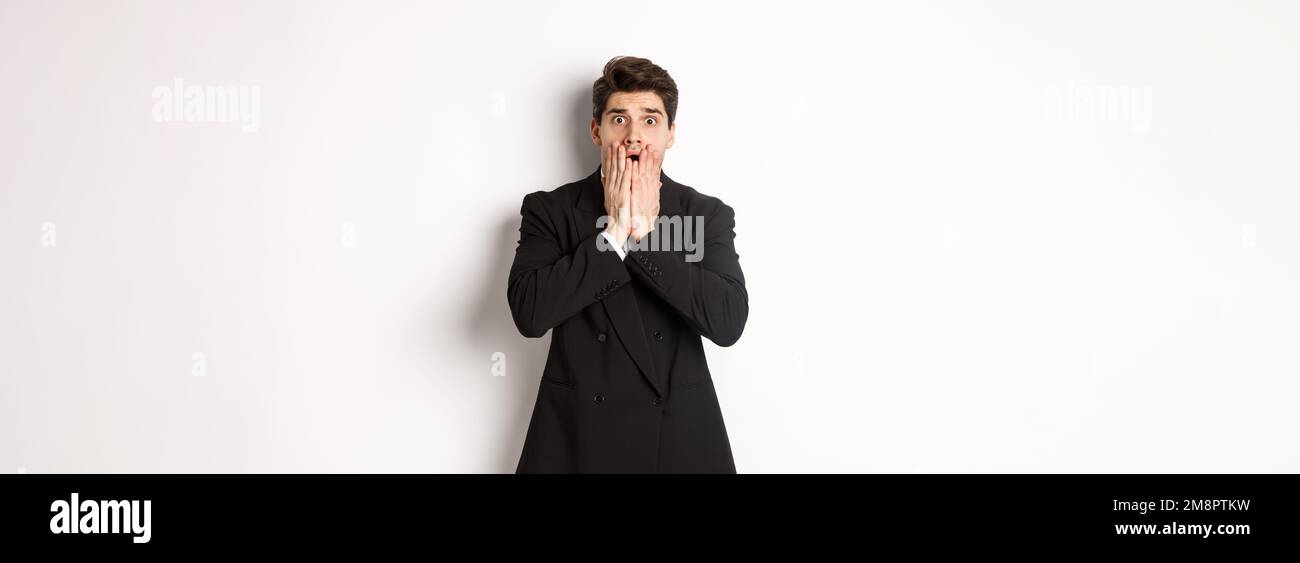 Image of concerned and scared man in black suit, gasping and looking ...