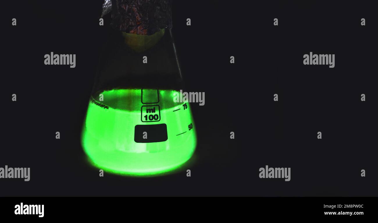A Laboratory flask glowing in the dark. Alchemy magic potion. Green ...