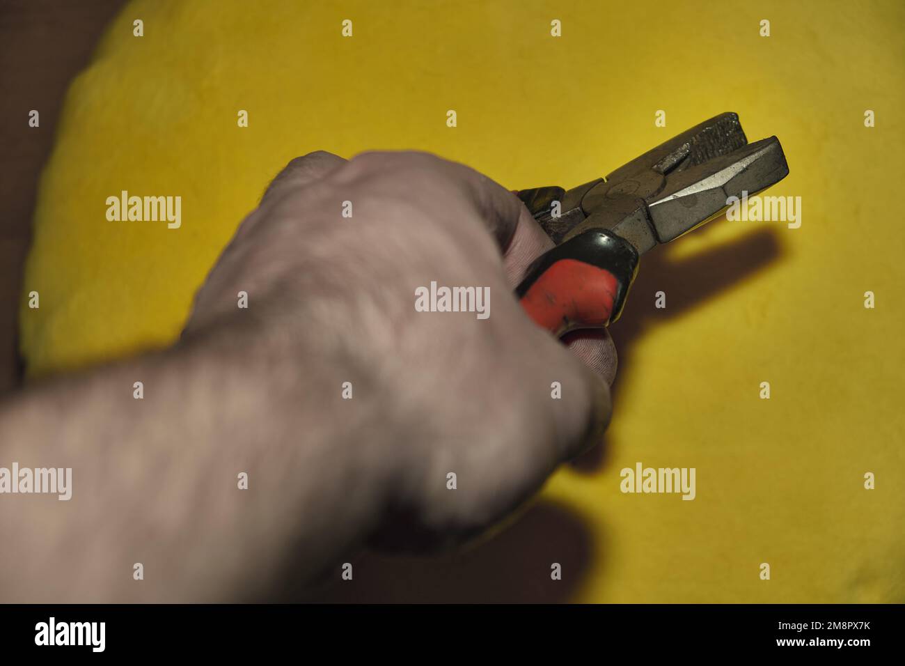 Pliers Open metal nippers with a red handle isolated on yellow ...