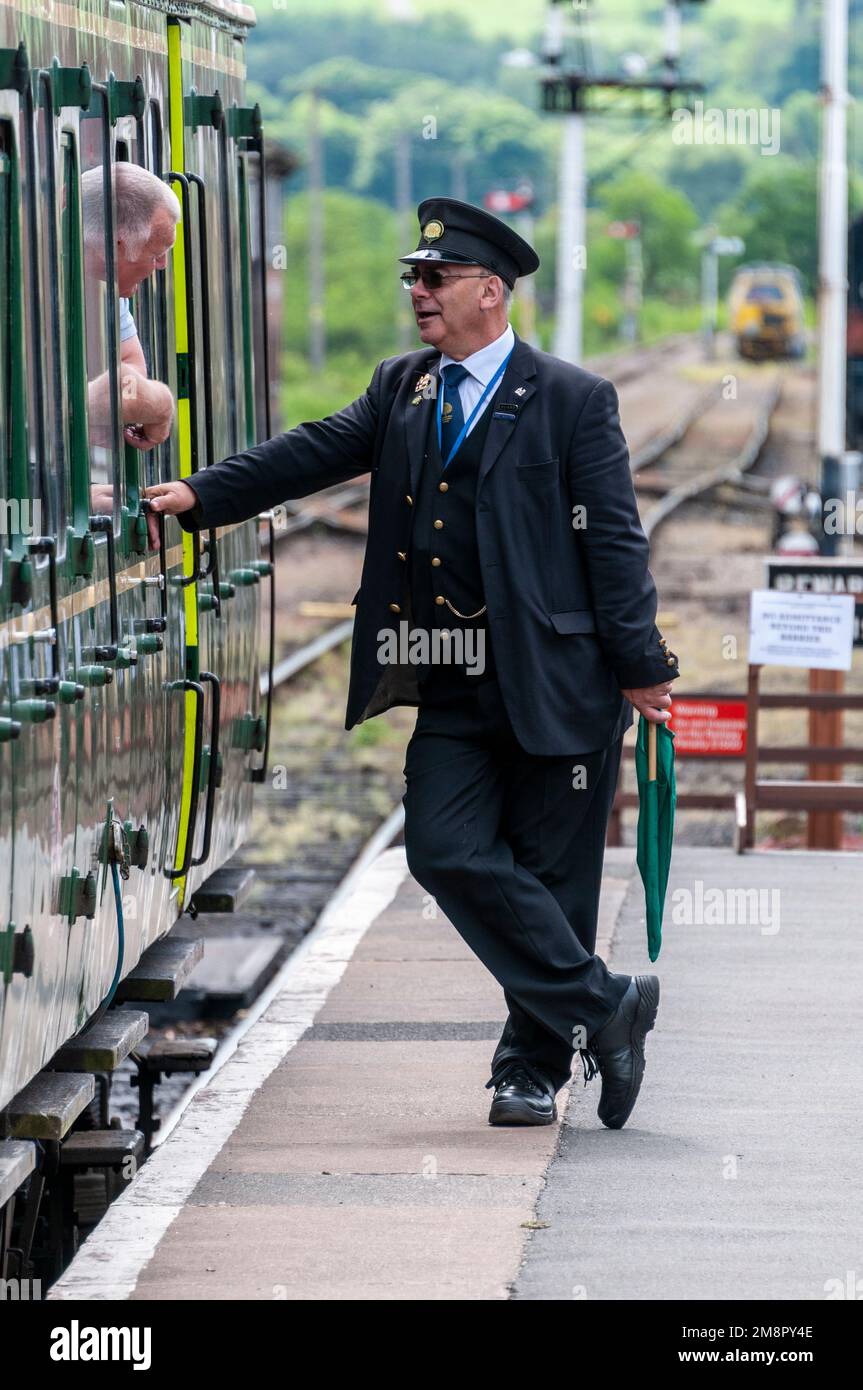 A train guard chats to a passenger on board a BR Class 122 DMU ...
