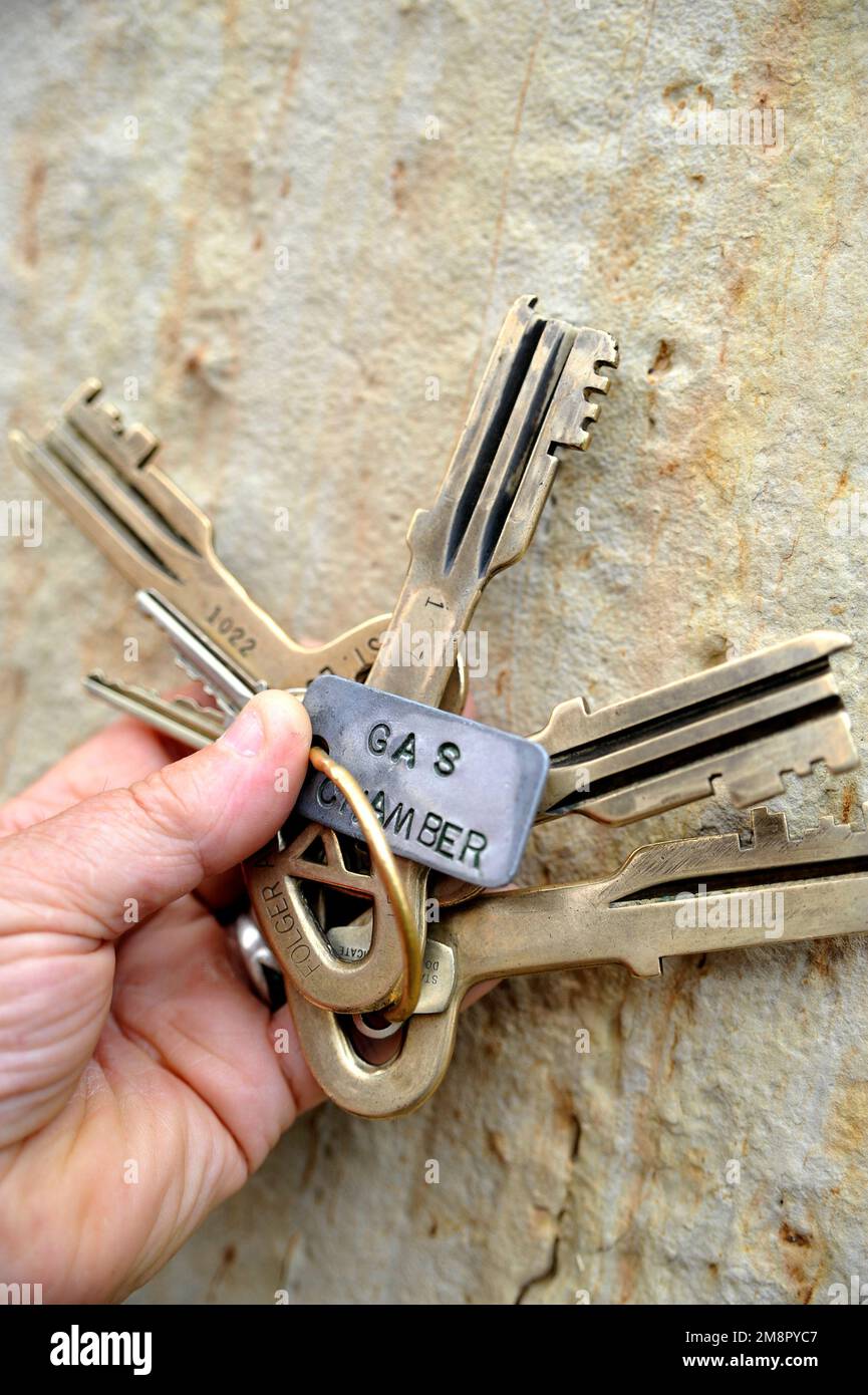 A vertical shot of a person's hand holding gas chamber keys at a prison ...