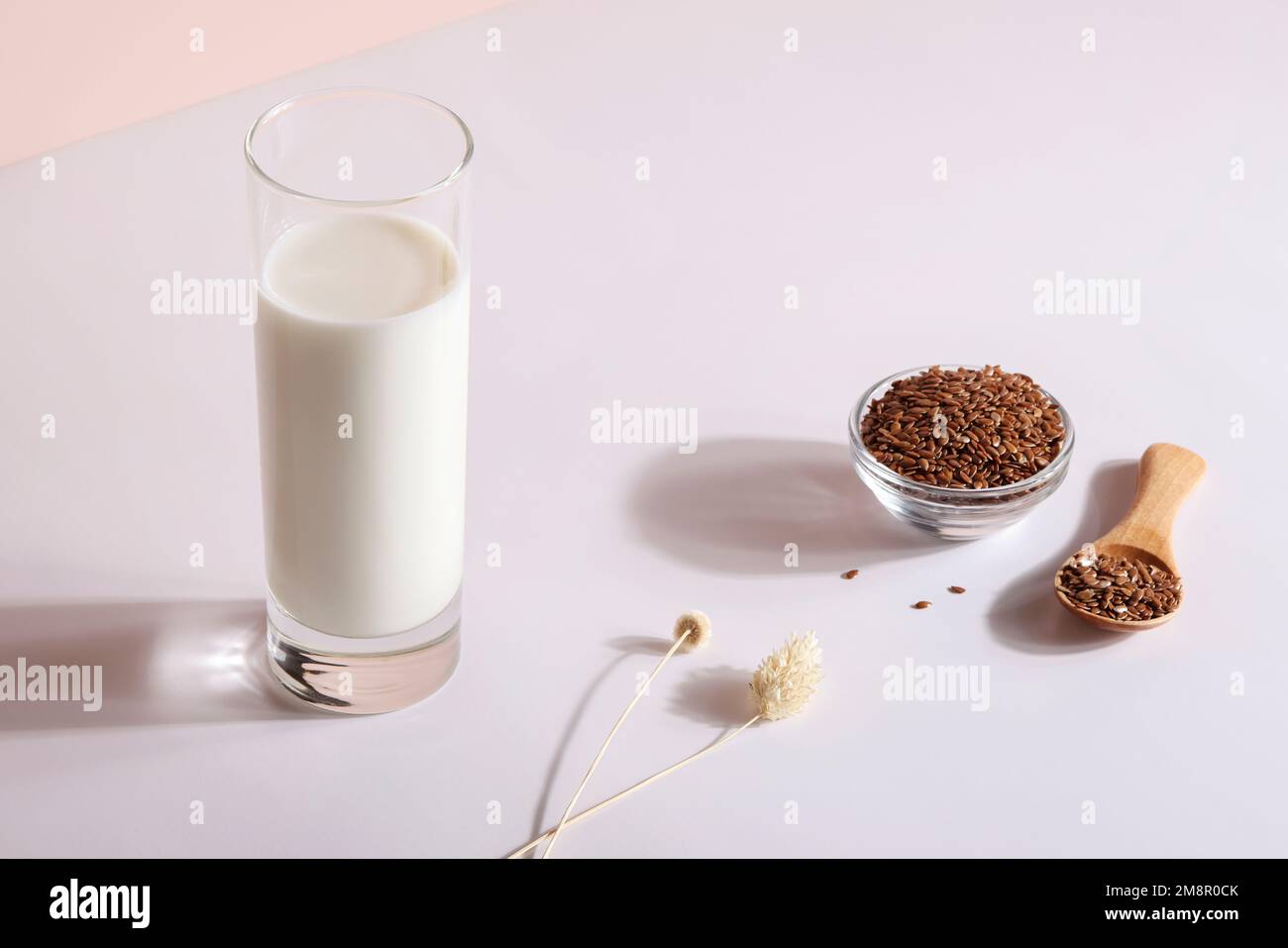 flax seed milk in glass on white background with plant. copy space. Raw ...