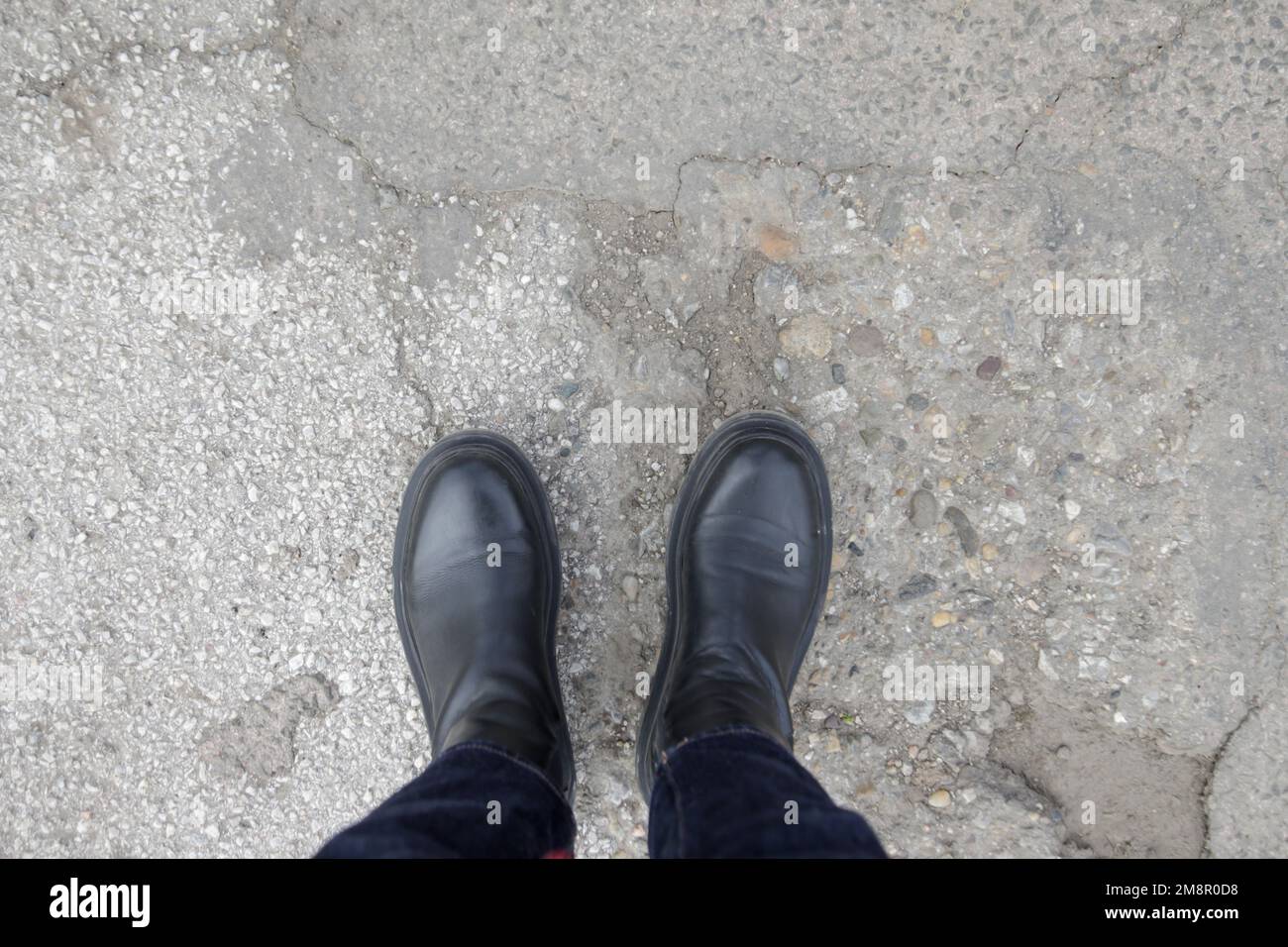 Person in chunky platform leather boots on asphalt, top view Stock ...