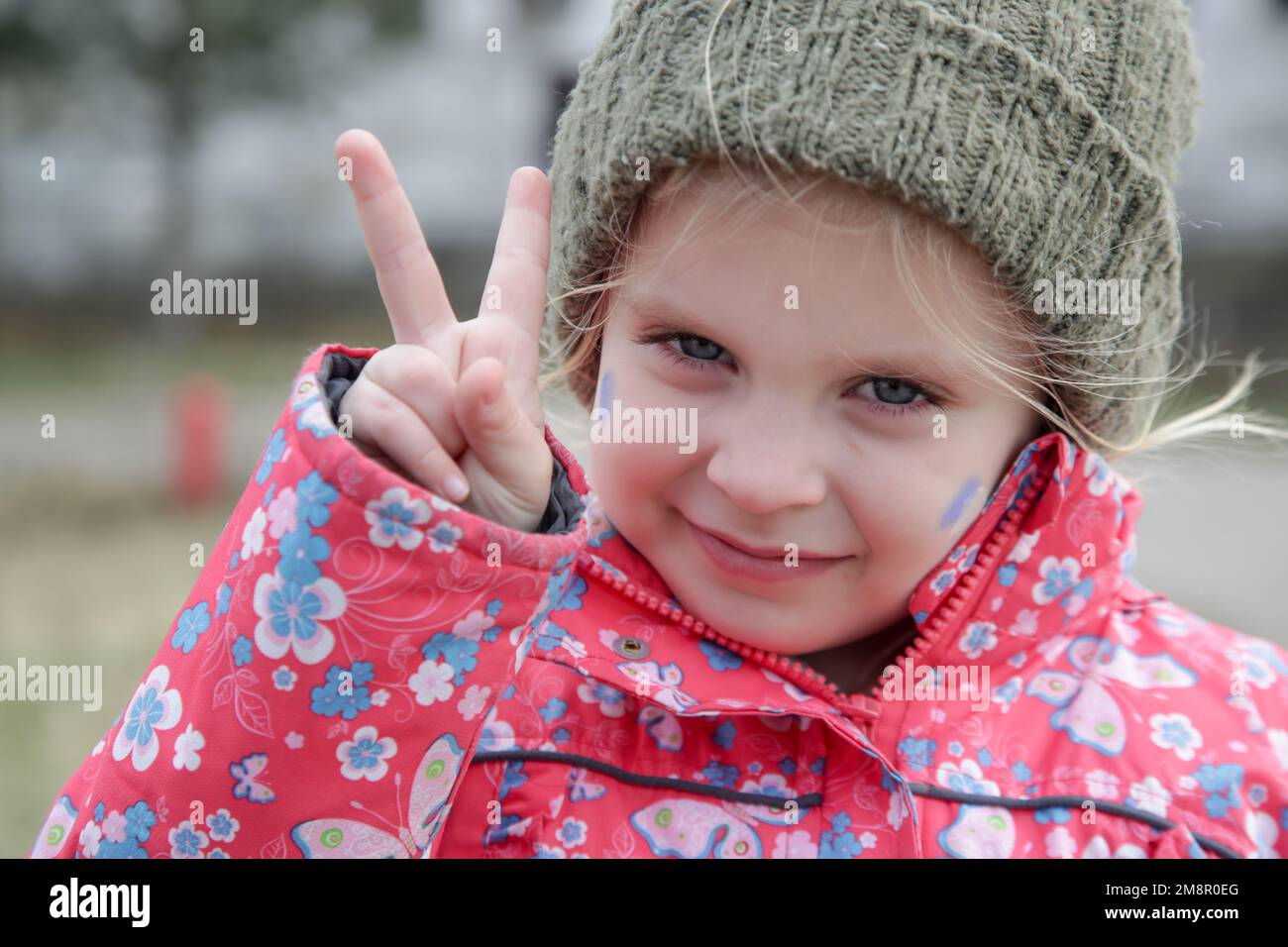 Portrait of little girl with Ukraine flag painted on her face showing ...