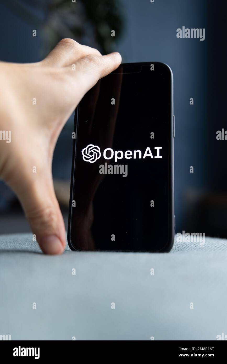 Woman's hand holding an iPhone with OpenAI logo. ChatGPT and Chat bot ...