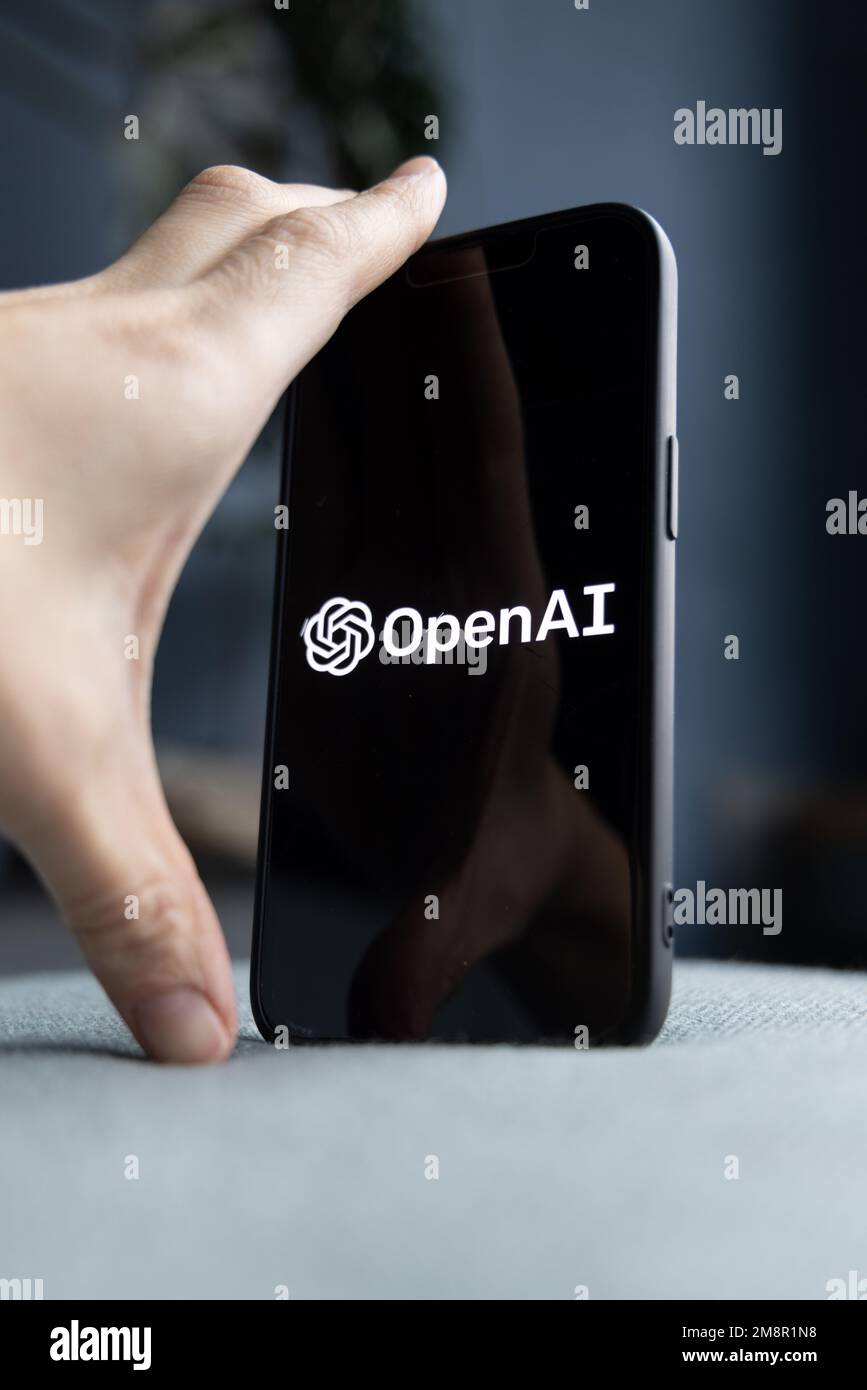 Woman's hand holding an iPhone with OpenAI logo. ChatGPT and Chat bot ...