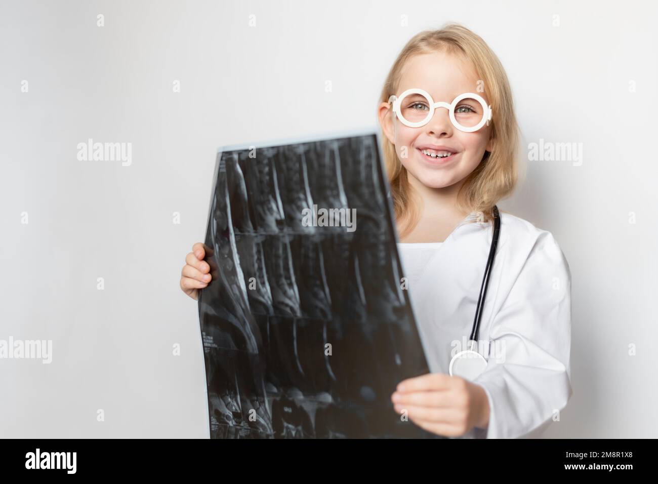 Caucasian child, little doctor with eyeglasses and stethoscope, holding ...