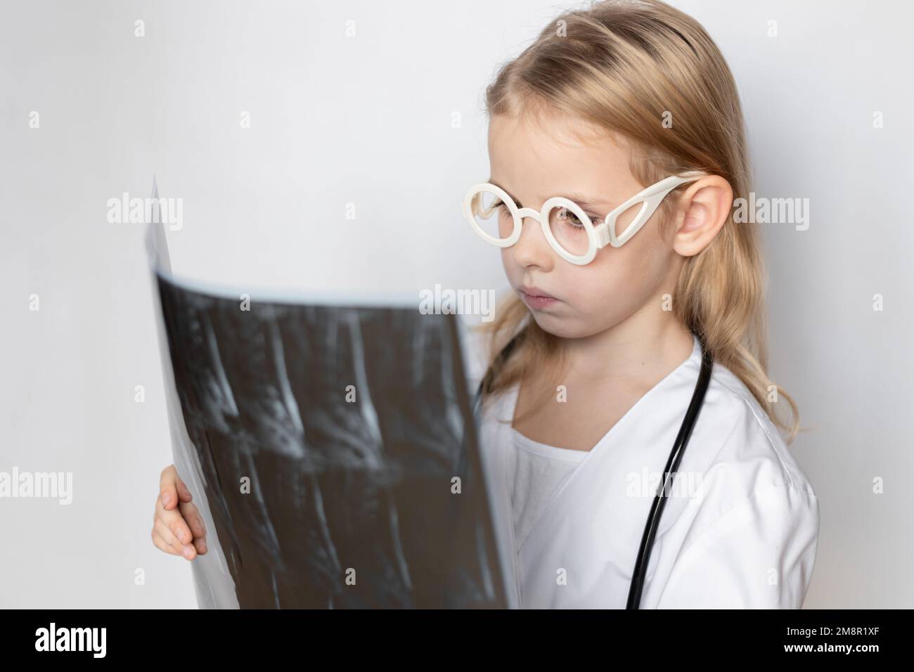 Doctor with eyeglasses and stethoscope, looking serious and holding x ...