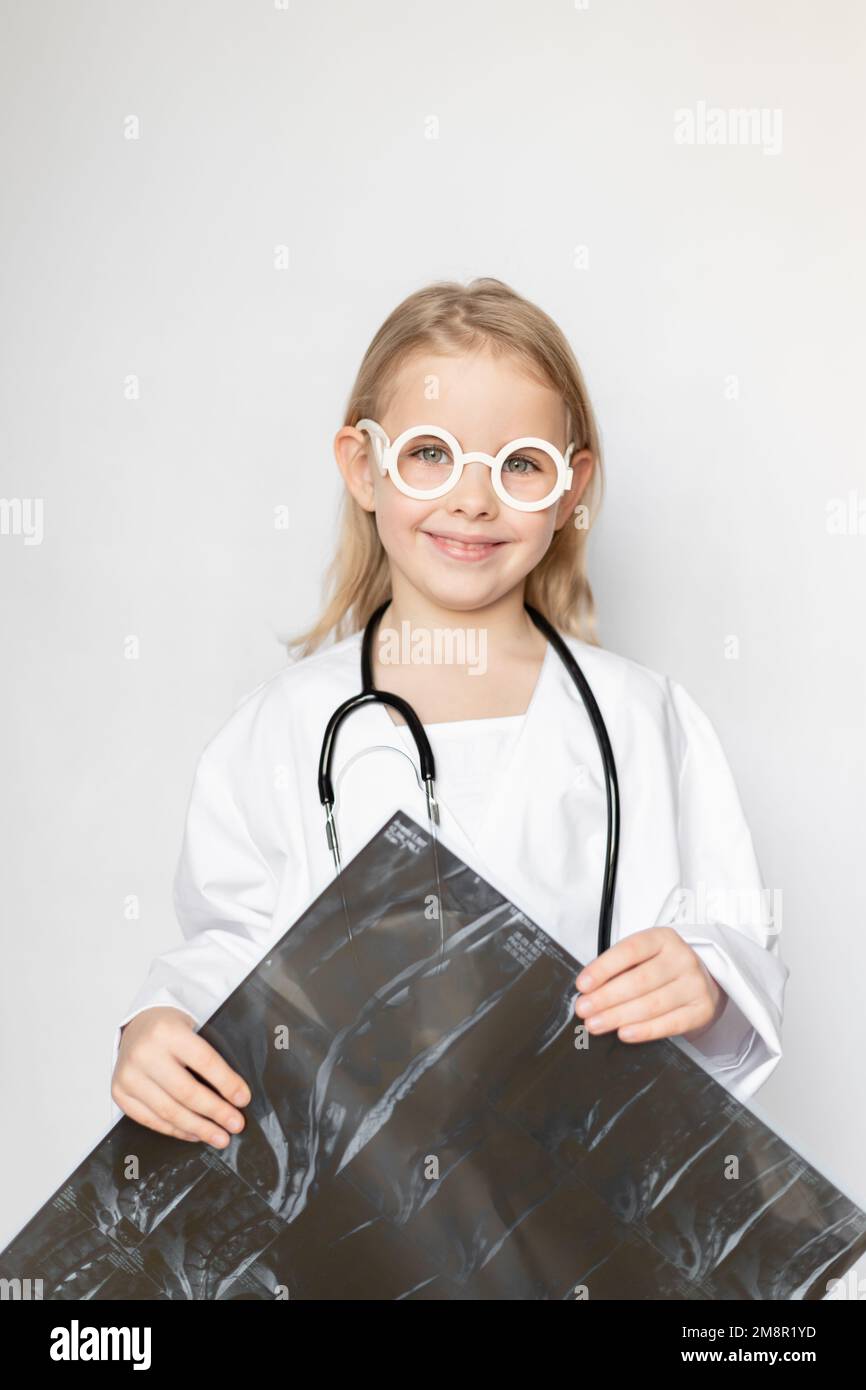 Caucasian child dressed up in doctor uniform with eyeglasses and ...