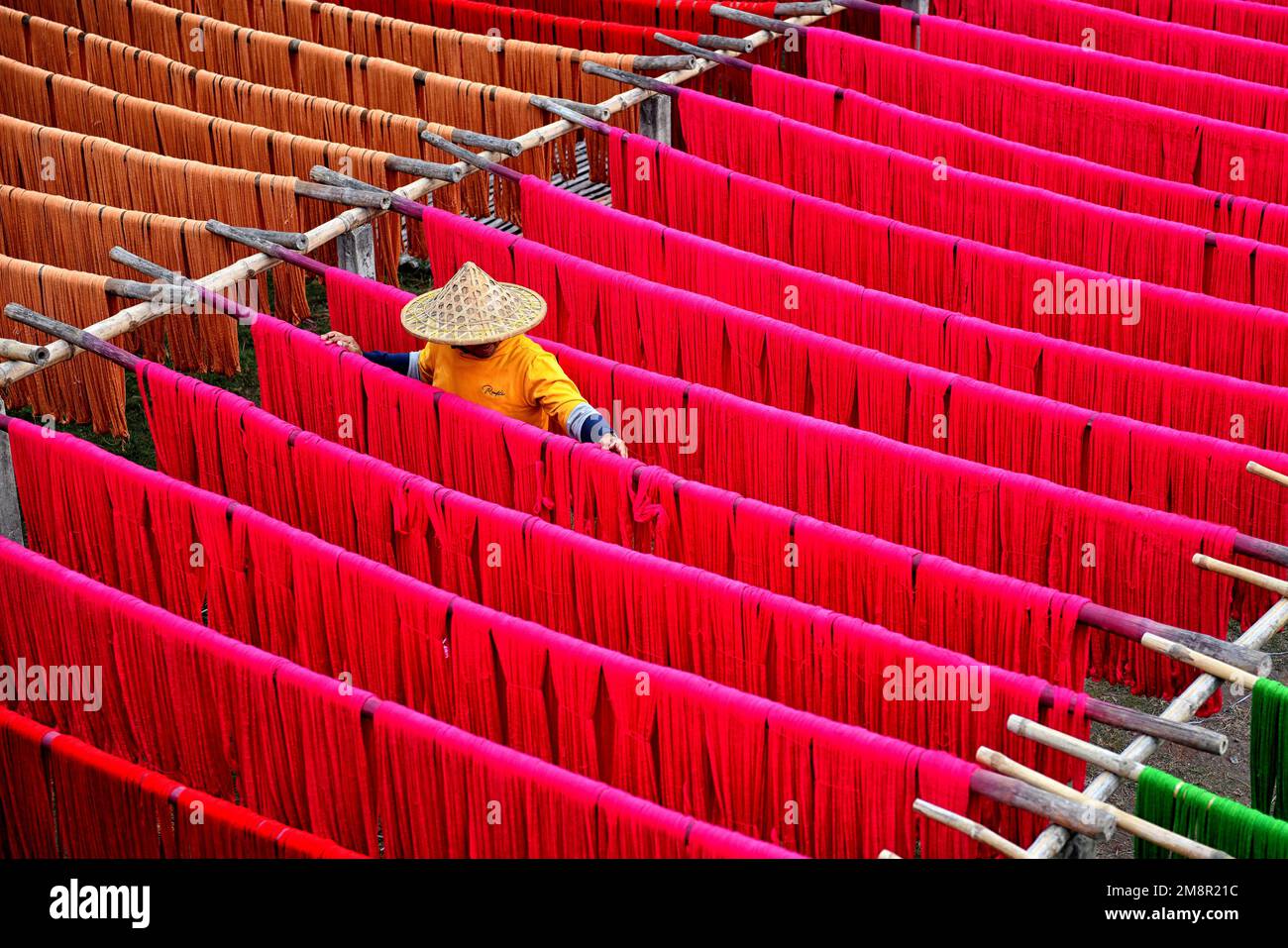 A weaver rinses the colourful Jute fibre to dry under sun which will be ...