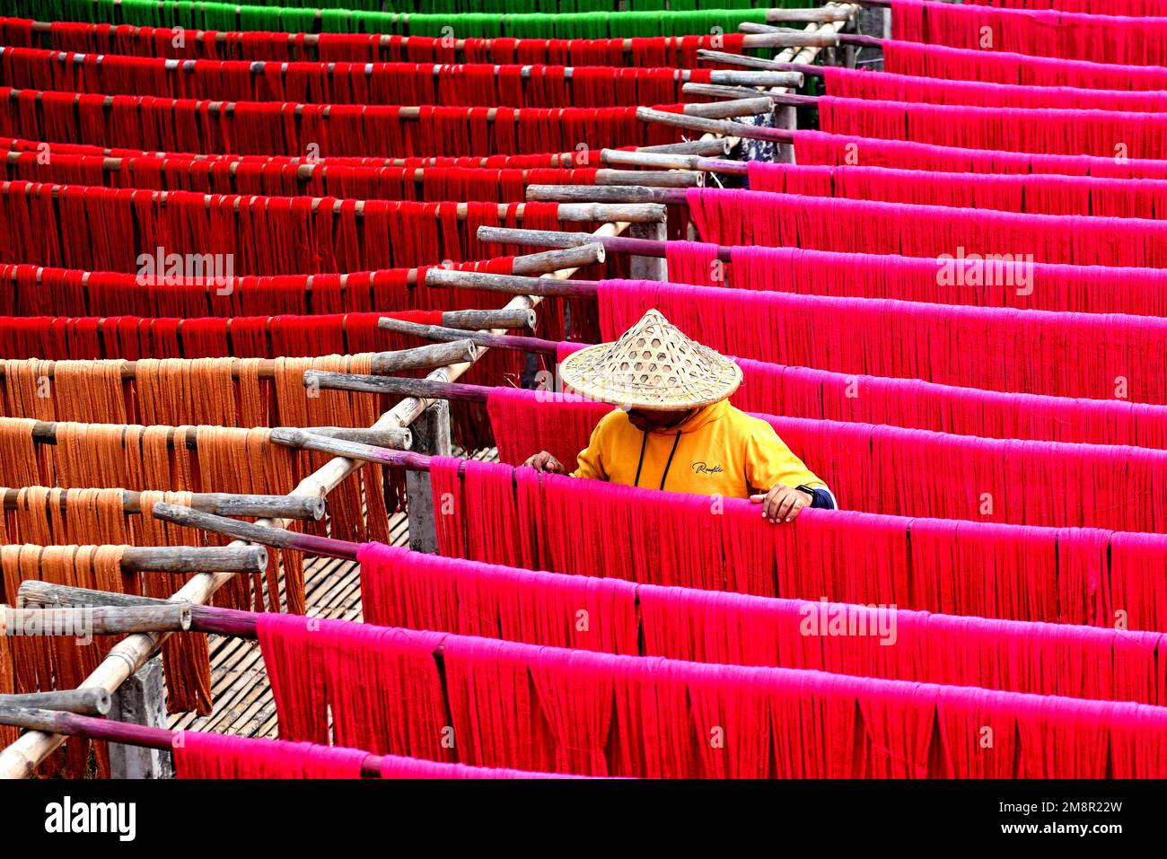 A weaver rinses the colourful Jute fibre to dry under sun which will be ...