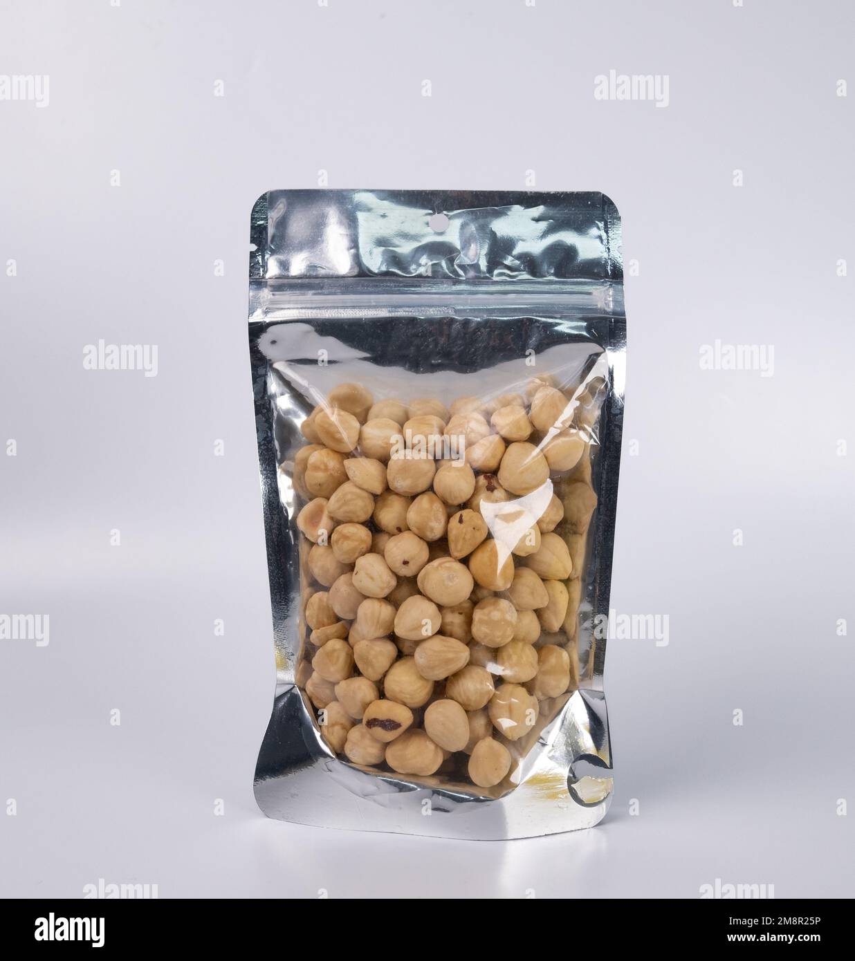 Peeled hazelnuts in doypack or transparent packaging. Nuts isolated in ...