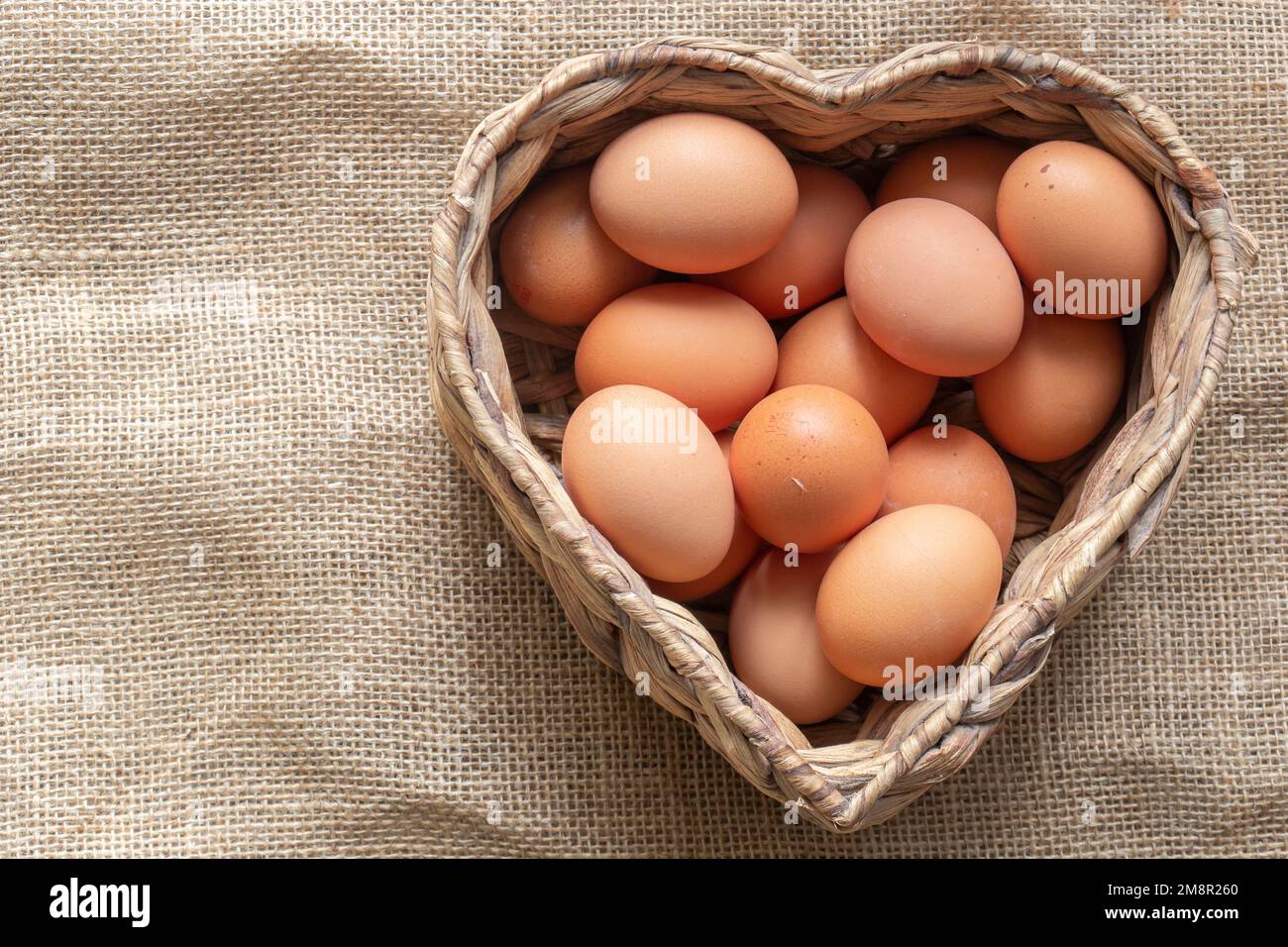 Free range chicken eggs in a heart shaped water hyacinth wicker basket ...