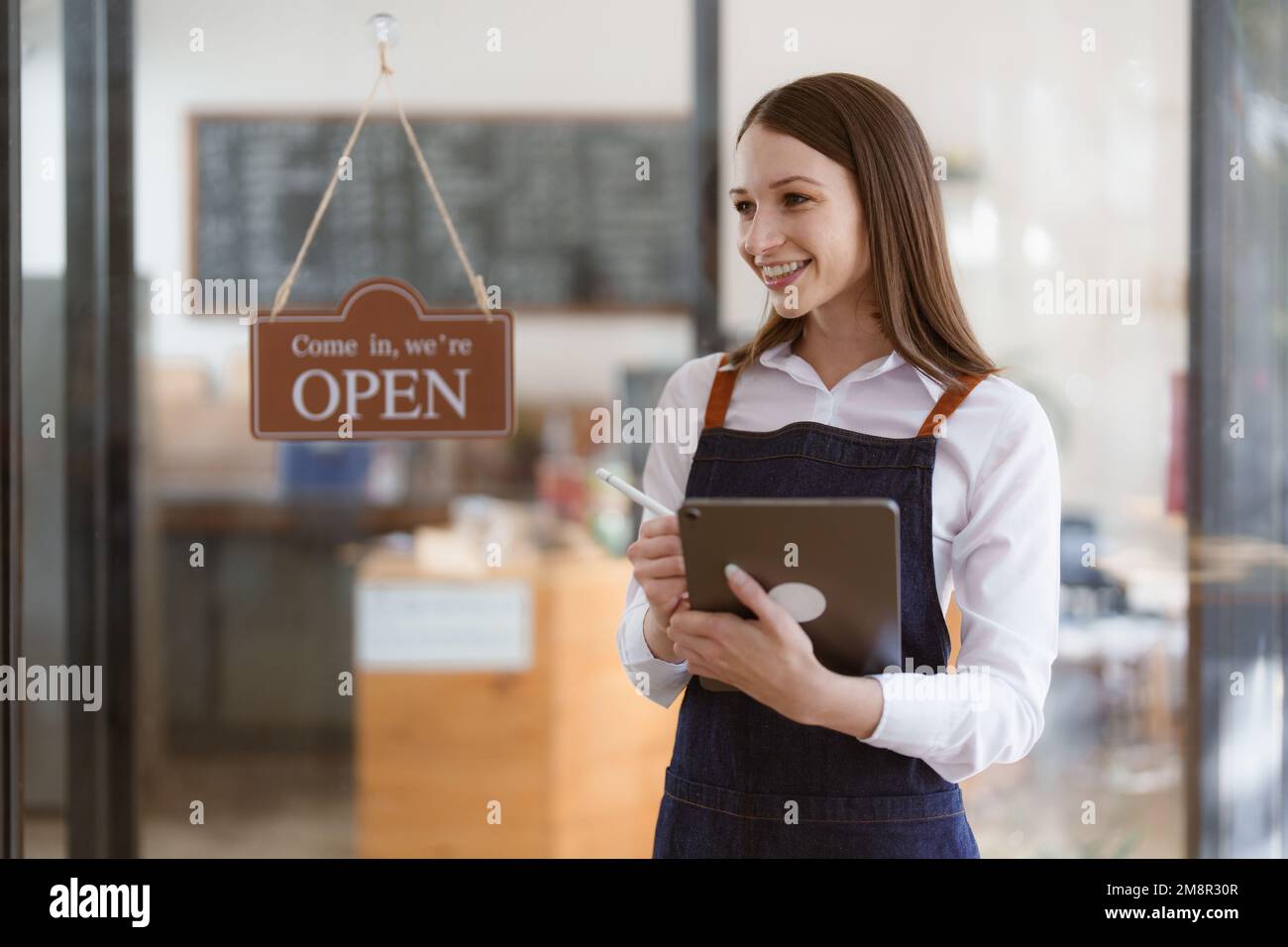 Young Female manager in restaurant with tablet. Woman coffee shop owner ...