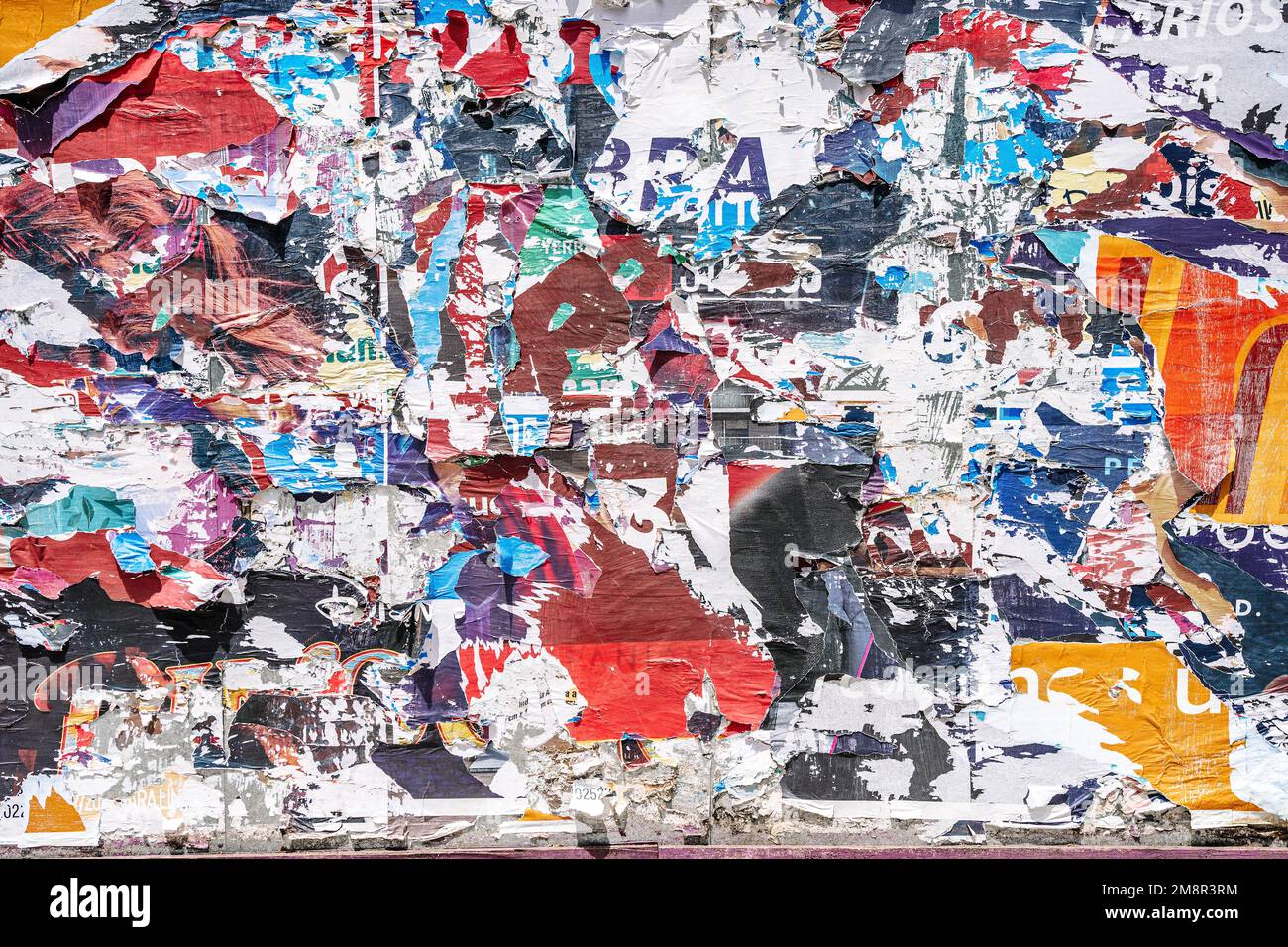 Torn paper collage background on an old poster on a street wall ...