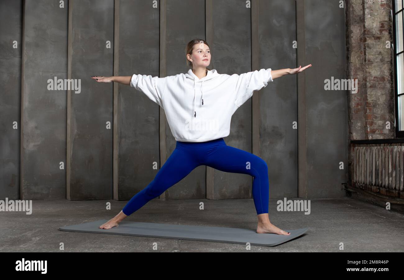 The Pilates coach shows the warrior pose. The athlete is practicing the ...