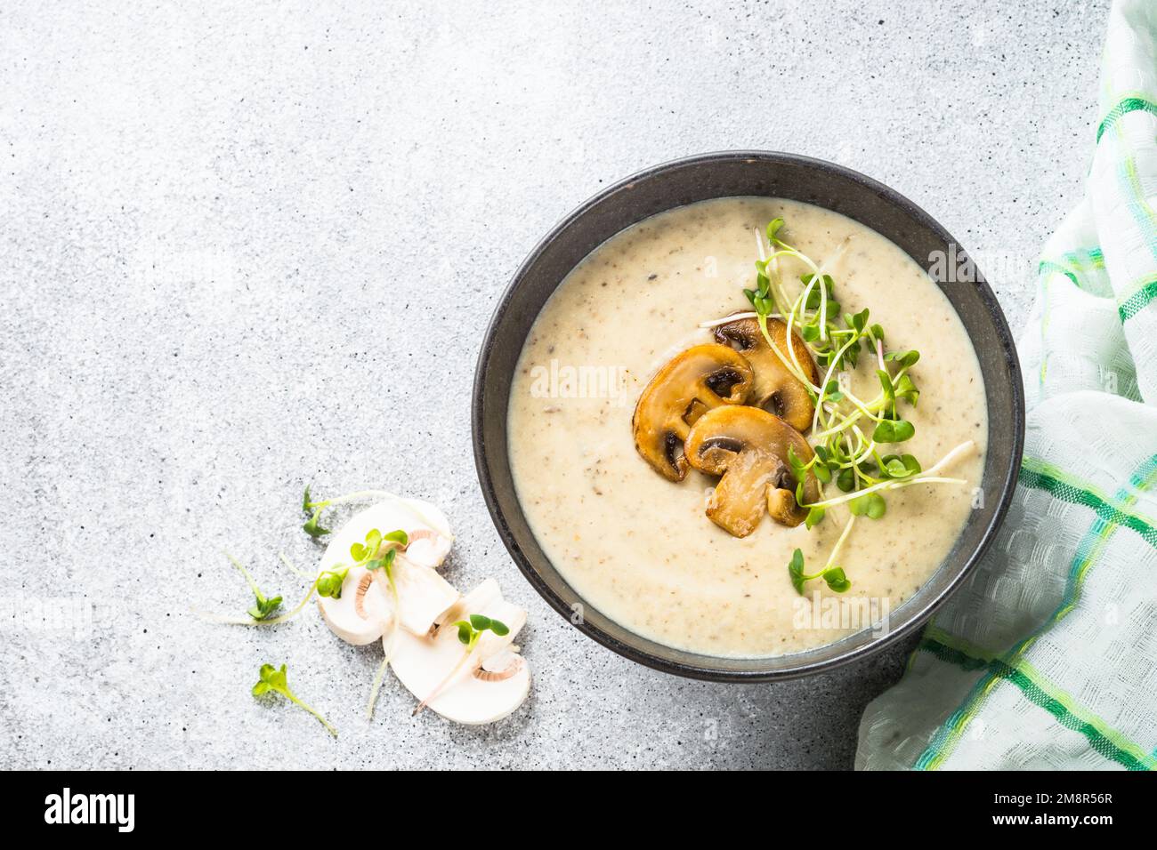 Mushroom Soup in black bowl on light stone table. Champignon cream soup ...