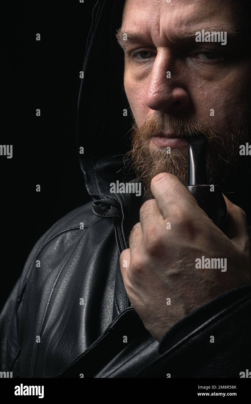 Portrait of a Bearded man in Black Rain Jacket Smoking a Pipe Stock ...