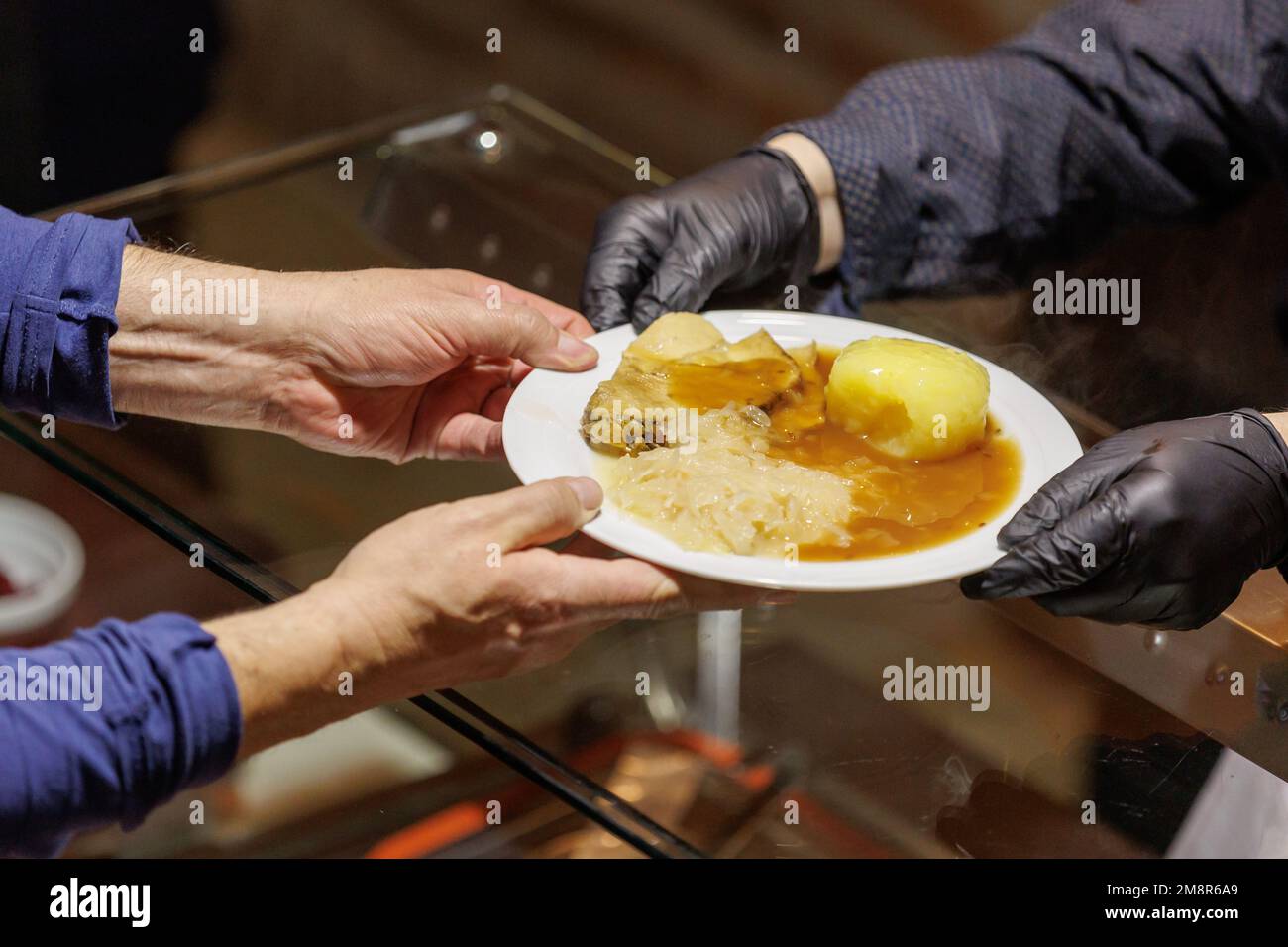 Nuremberg, Germany. 15th Jan, 2023. A man accepts his lunch at the food ...