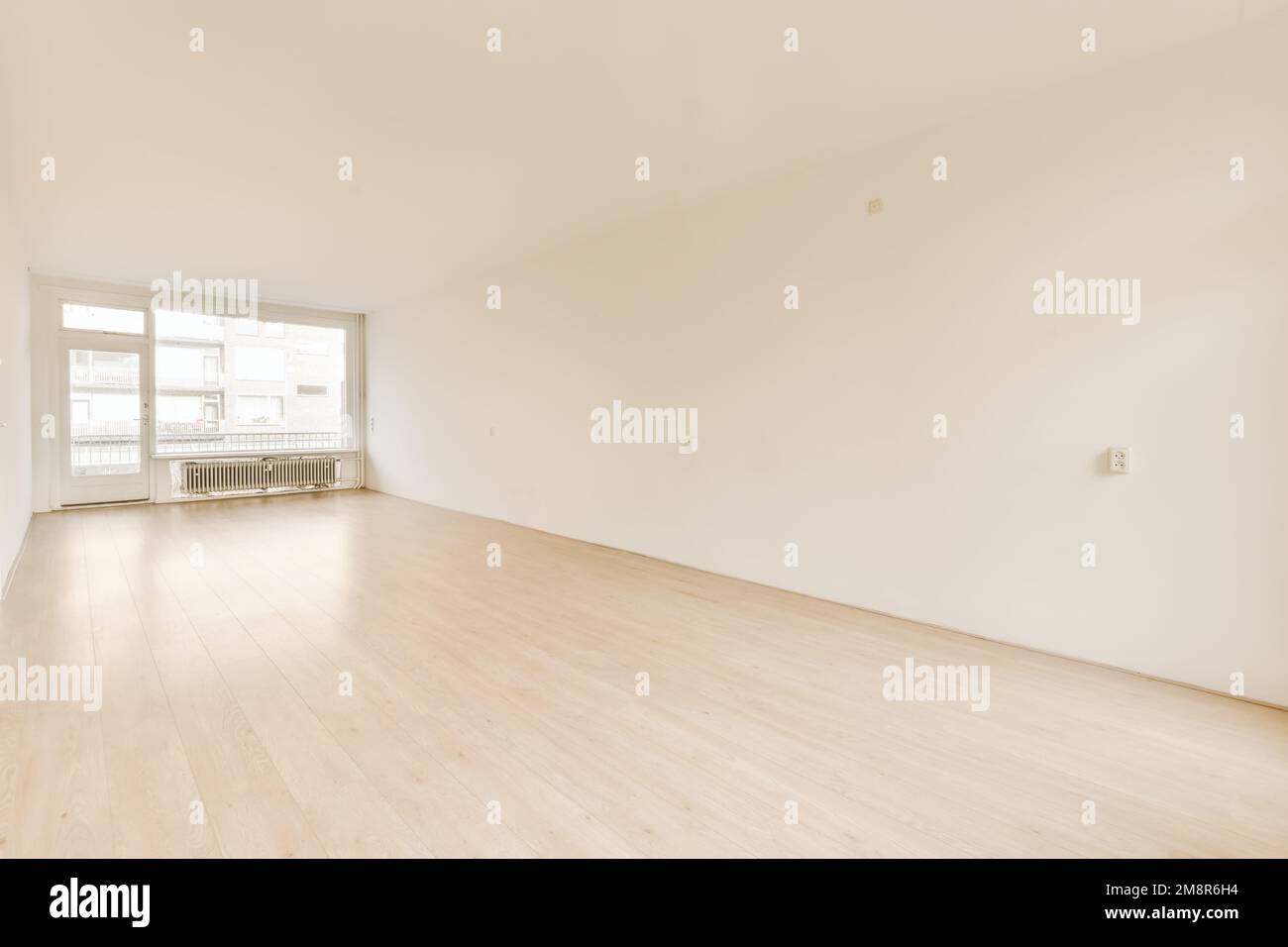 an empty living room with wood flooring and white walls, there is a ...