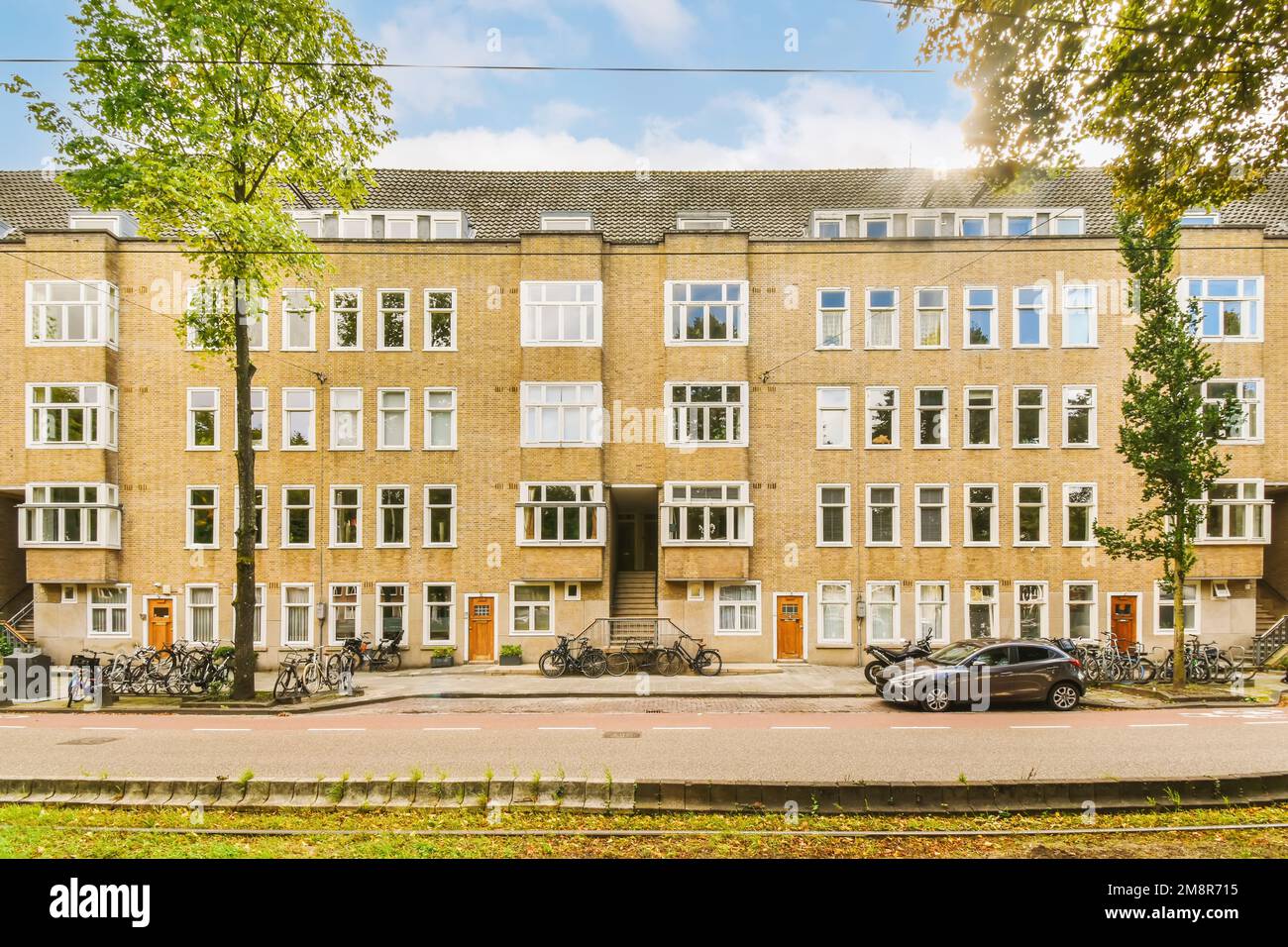 an apartment building with bicycles parked on the street in front of it ...