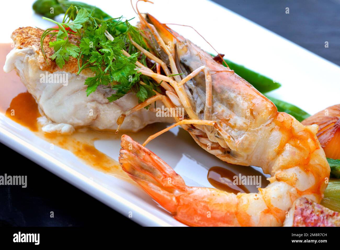 Close up of a shrimp and cod fillet on a plate Stock Photo - Alamy