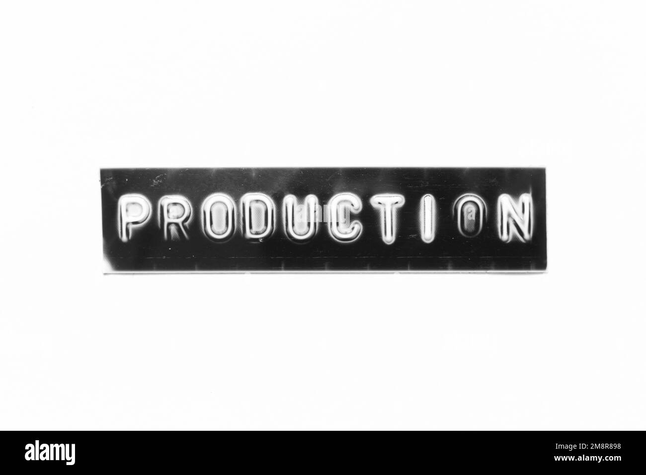 Embossed letter with word production in black banner on white paper ...