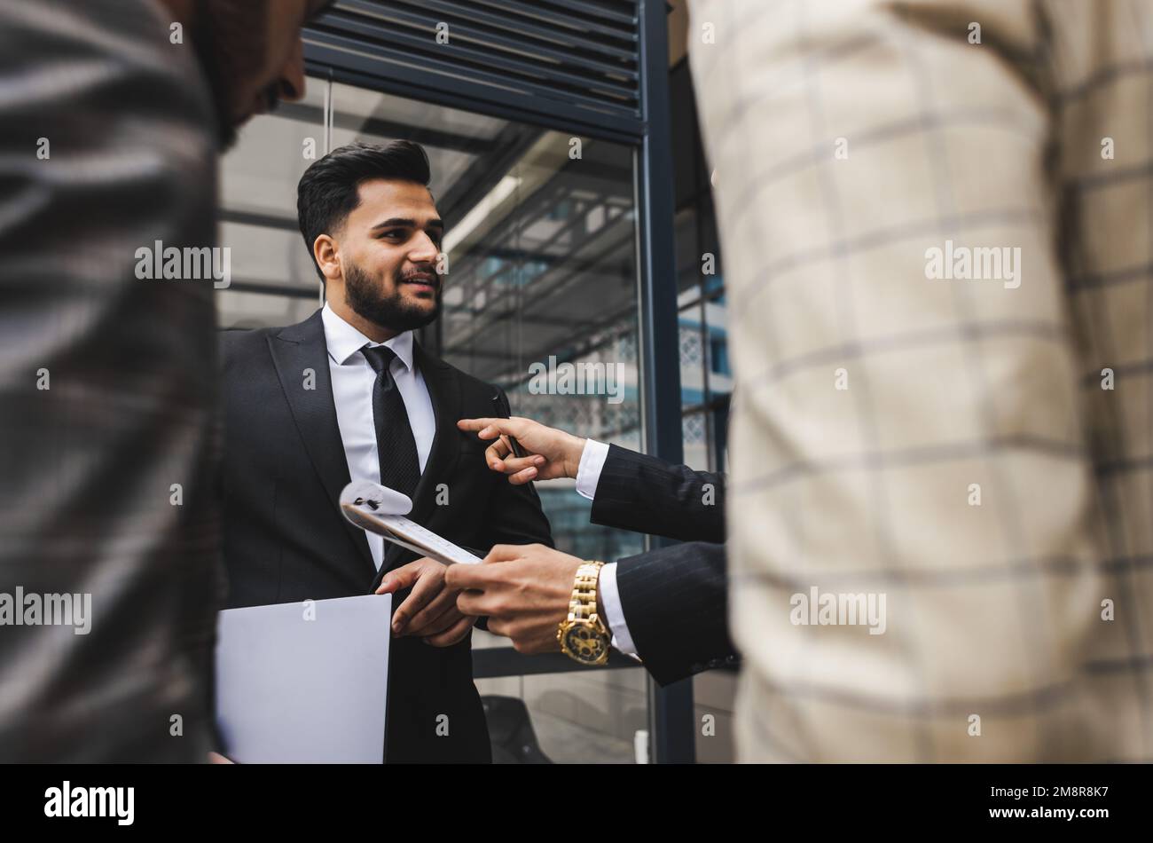 Business people outdoor meeting. Men in jackets discuss working moments ...
