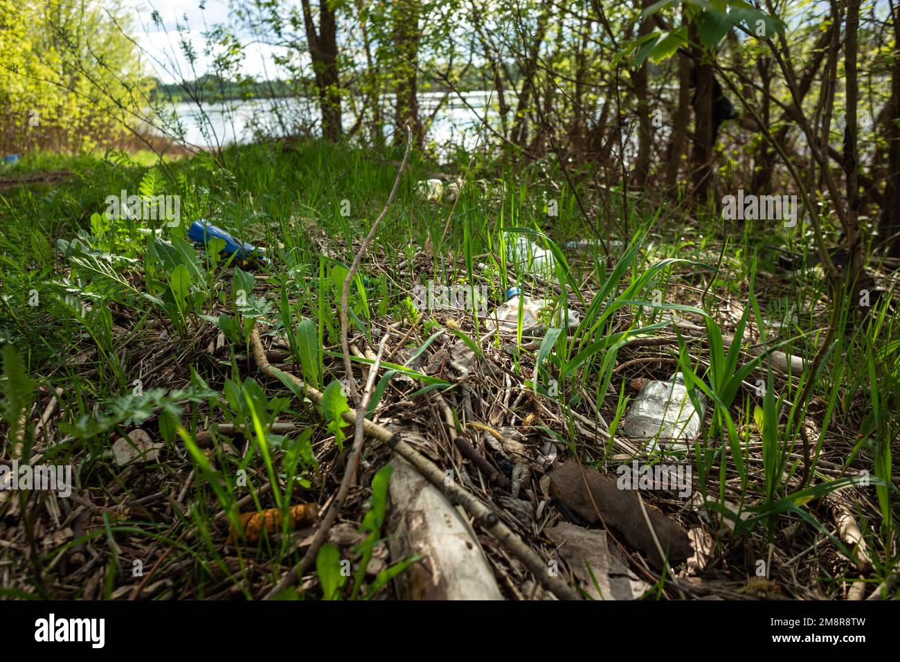 Abandoned garbage plastic and glass waste in nature among the grass ...